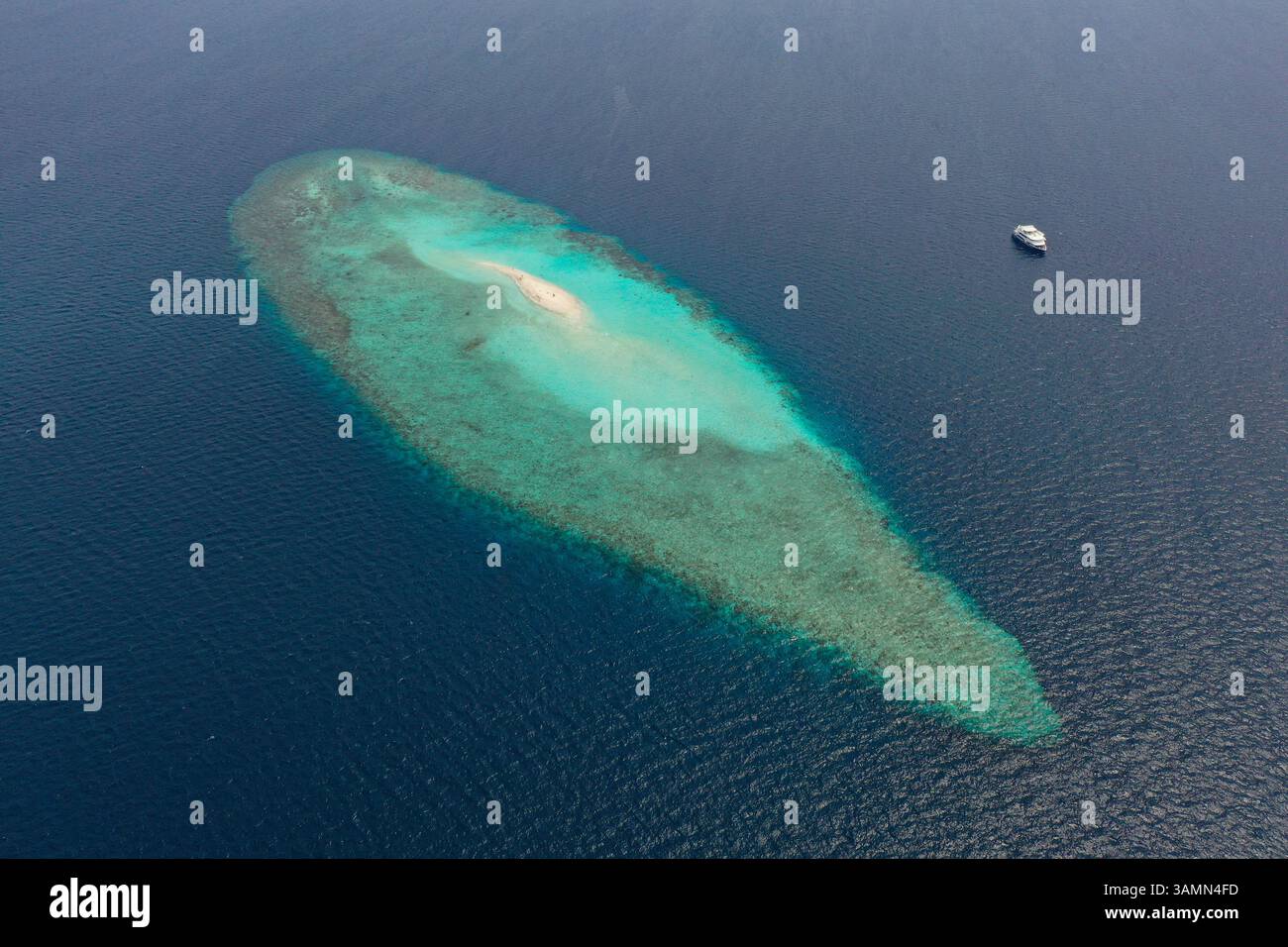 Aerial view of a small boat along the reef of Malè Atoll, Maldives ...