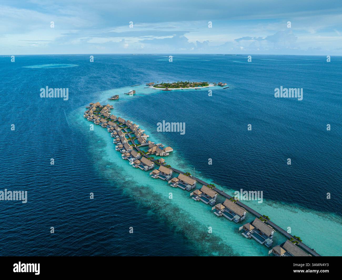 Aerial view of bungalows along the shore on Ithaafushi Island, Maldives ...
