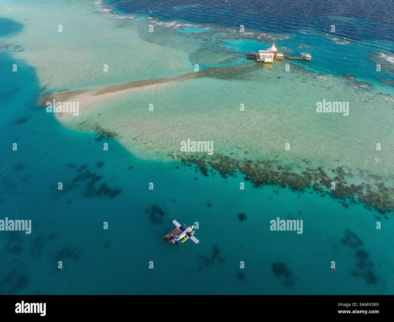 Aerial view of an airplane landing in the Indian Ocean near Huluwalu ...