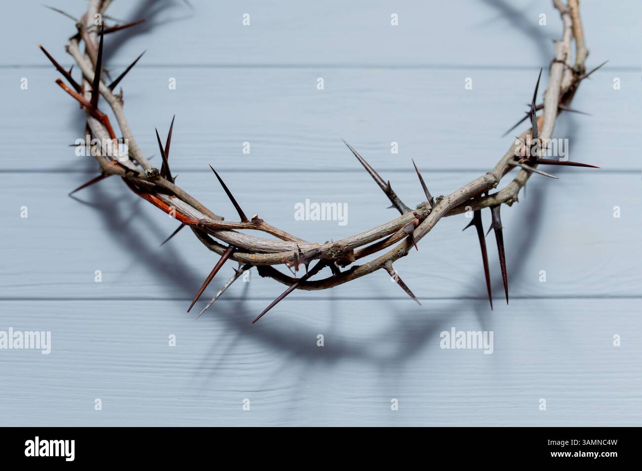 Wooden wall casting dark shadow from Jesus crown of thorns, symbolizing ...