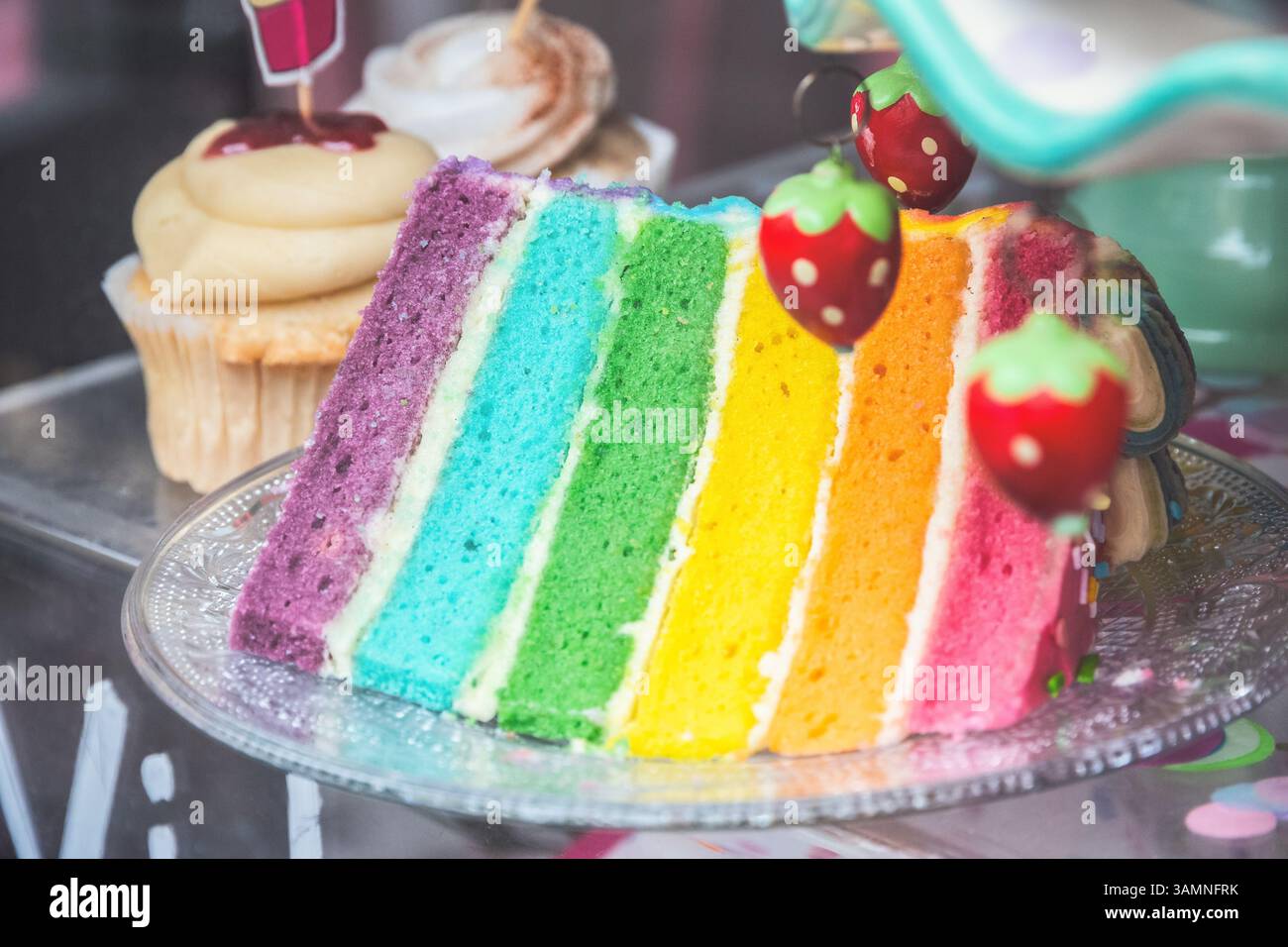 A slice of colourful rainbow sponge cake on display at Brick Lane ...