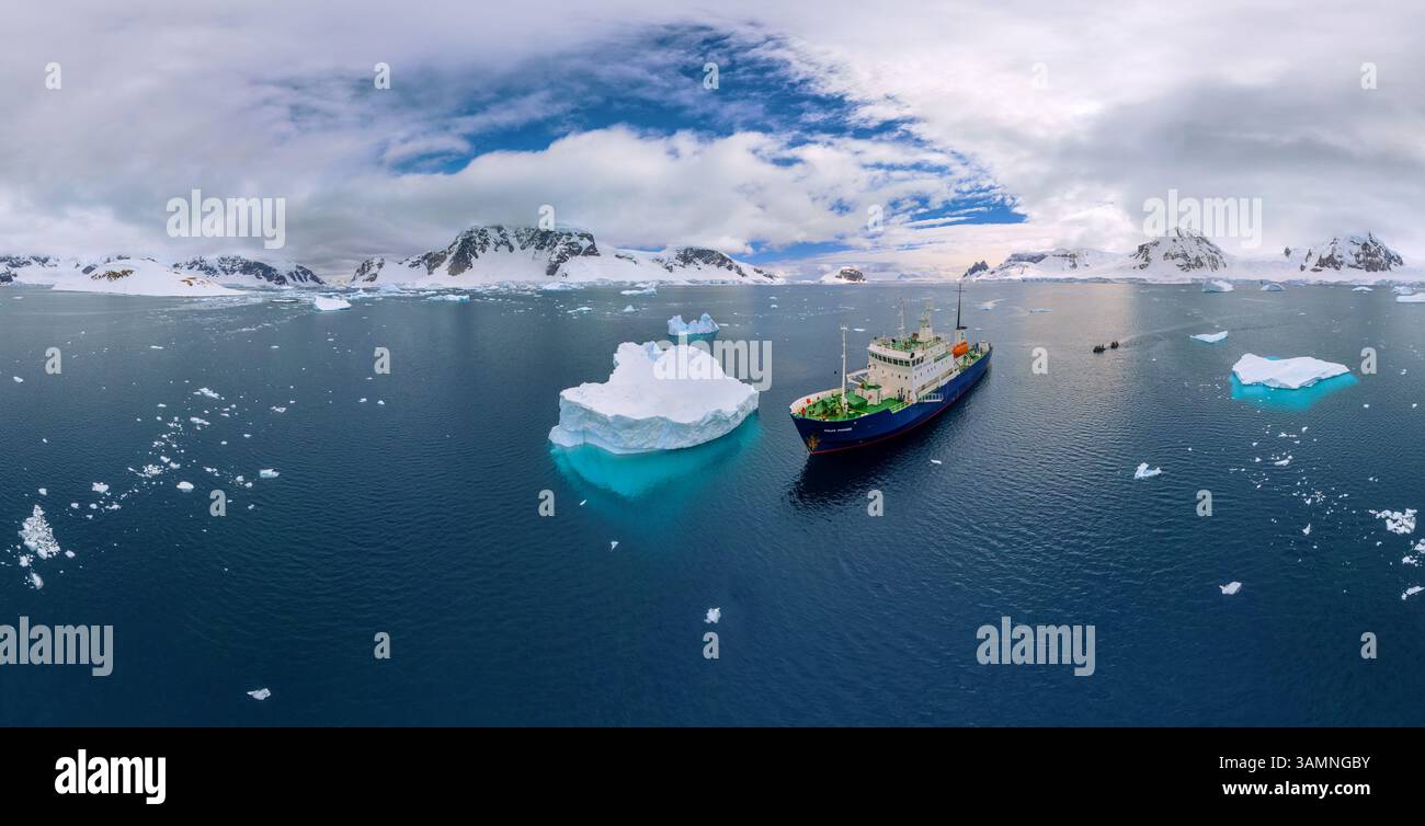 Aerial view Polar Pioneer, a scientific ship sailing near to an iceberg ...