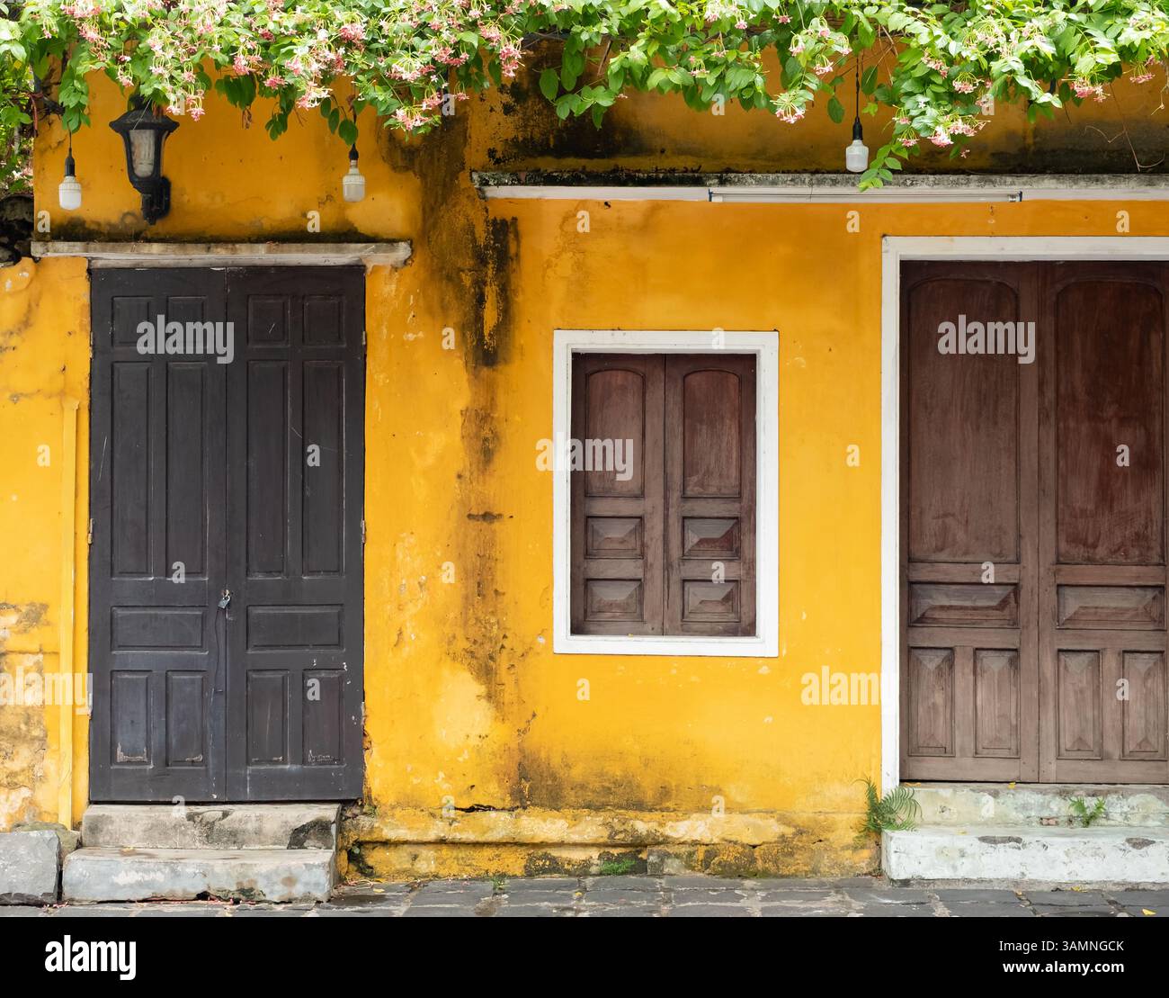 Facade of an ancient Asian house. Streets with traditional old yellow ...