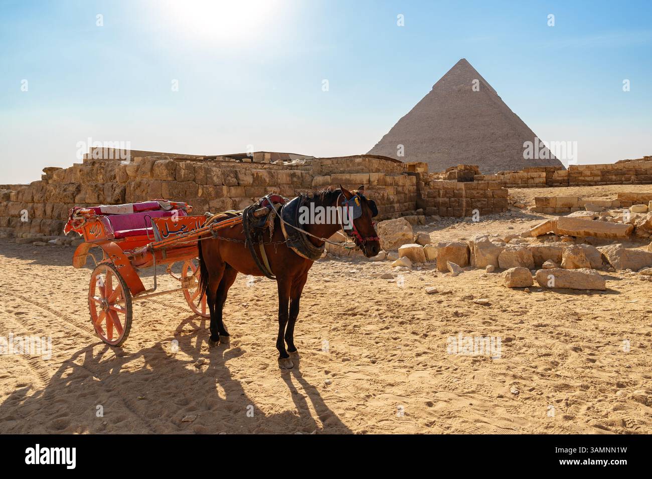 Horse-drawn carriage waits near the Great Pyramid of Giza under a ...