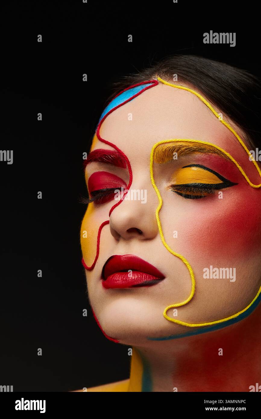 A young woman showcases stunning face art with bold colors, emphasizing ...