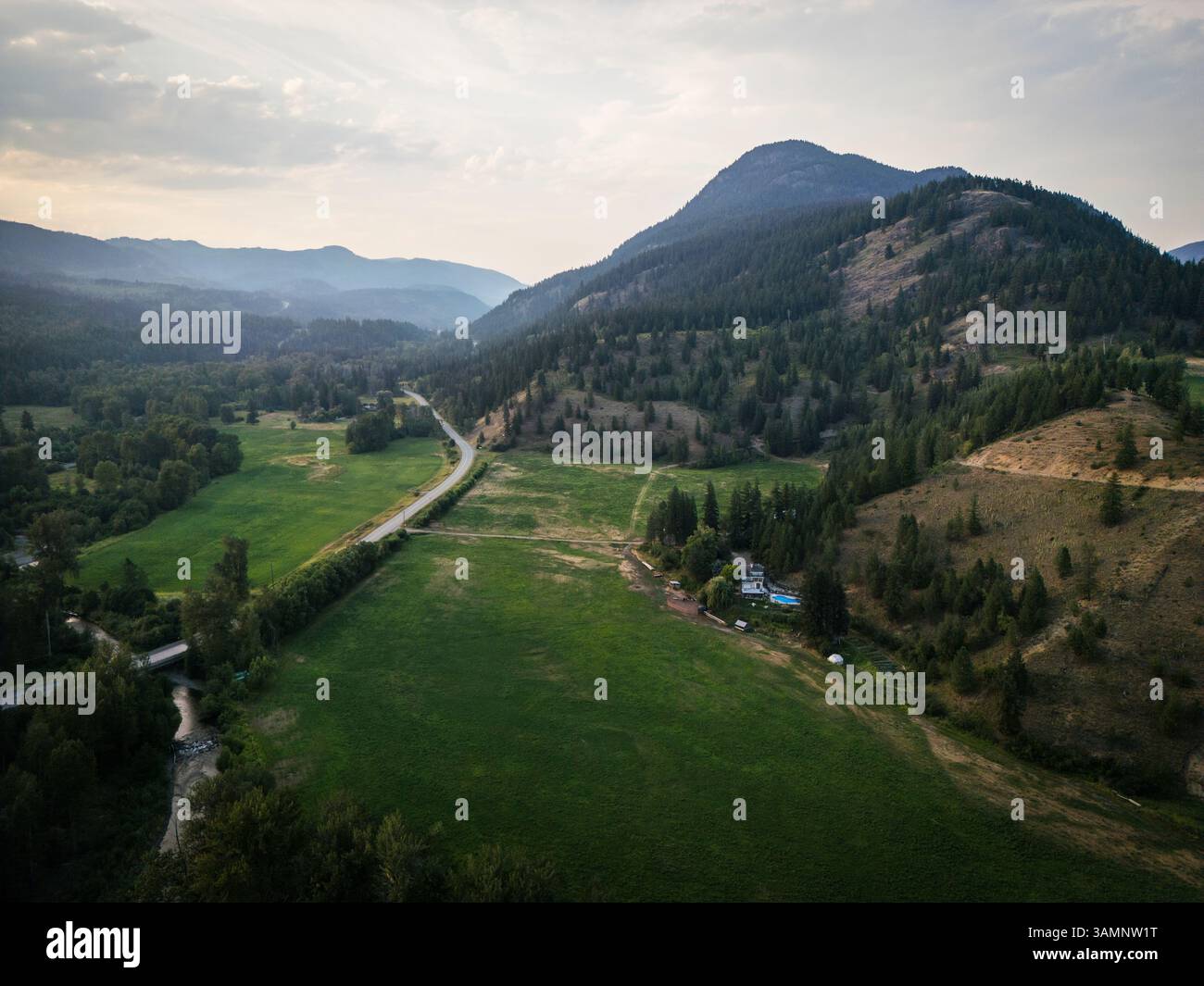 Aerial view of lush mountains and fields with a serene valley and ...