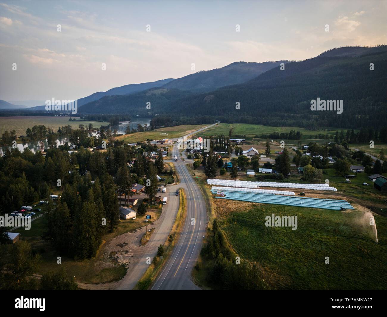 Aerial view of scenic mountains and lush fields with a peaceful road ...