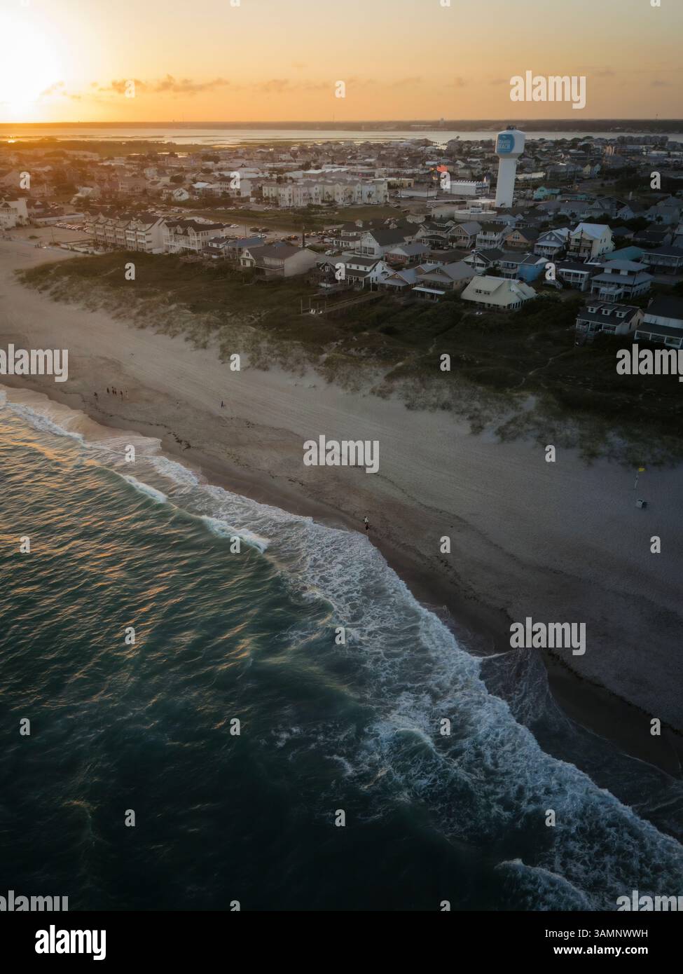 Aerial view of beautiful sunset over Atlantic Beach with people enjoying the sandy shore ...