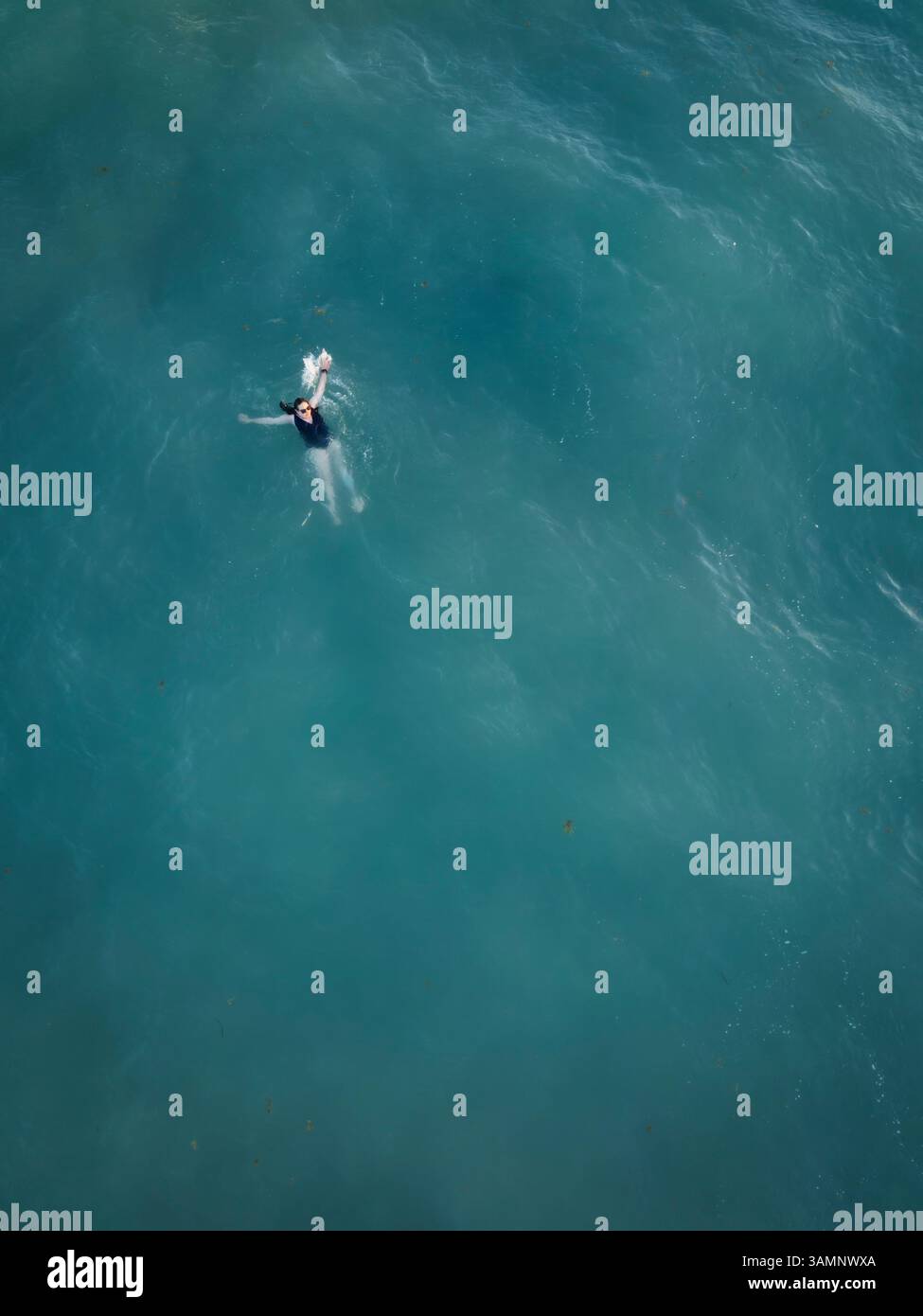 Aerial view of a serene person swimming in the calm Atlantic Ocean ...