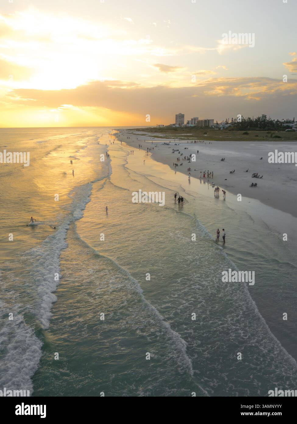 Aerial view of beautiful sunset over sandy beach with people and ...