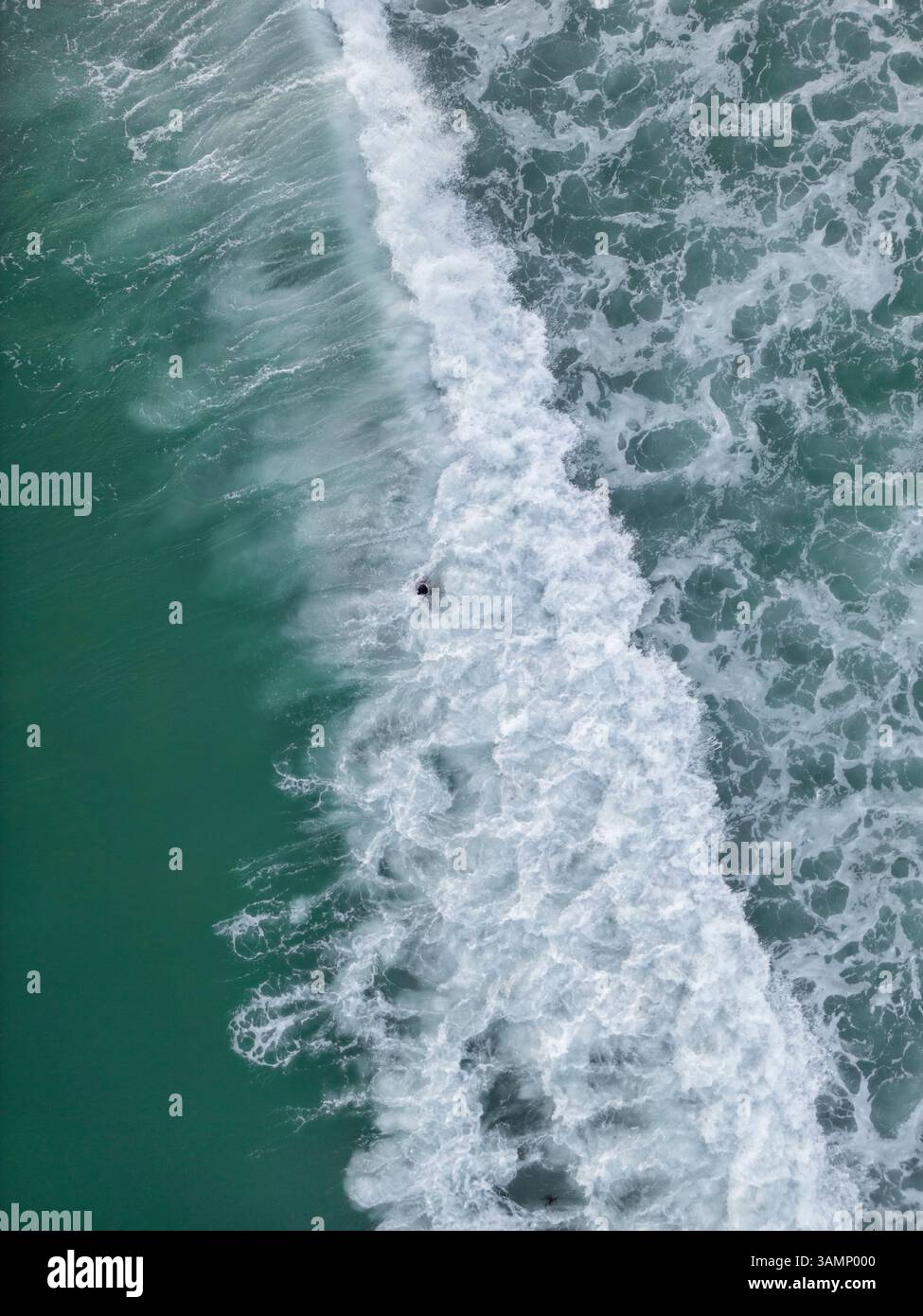 Aerial view of a surfer riding waves in the clear blue ocean, Siesta ...