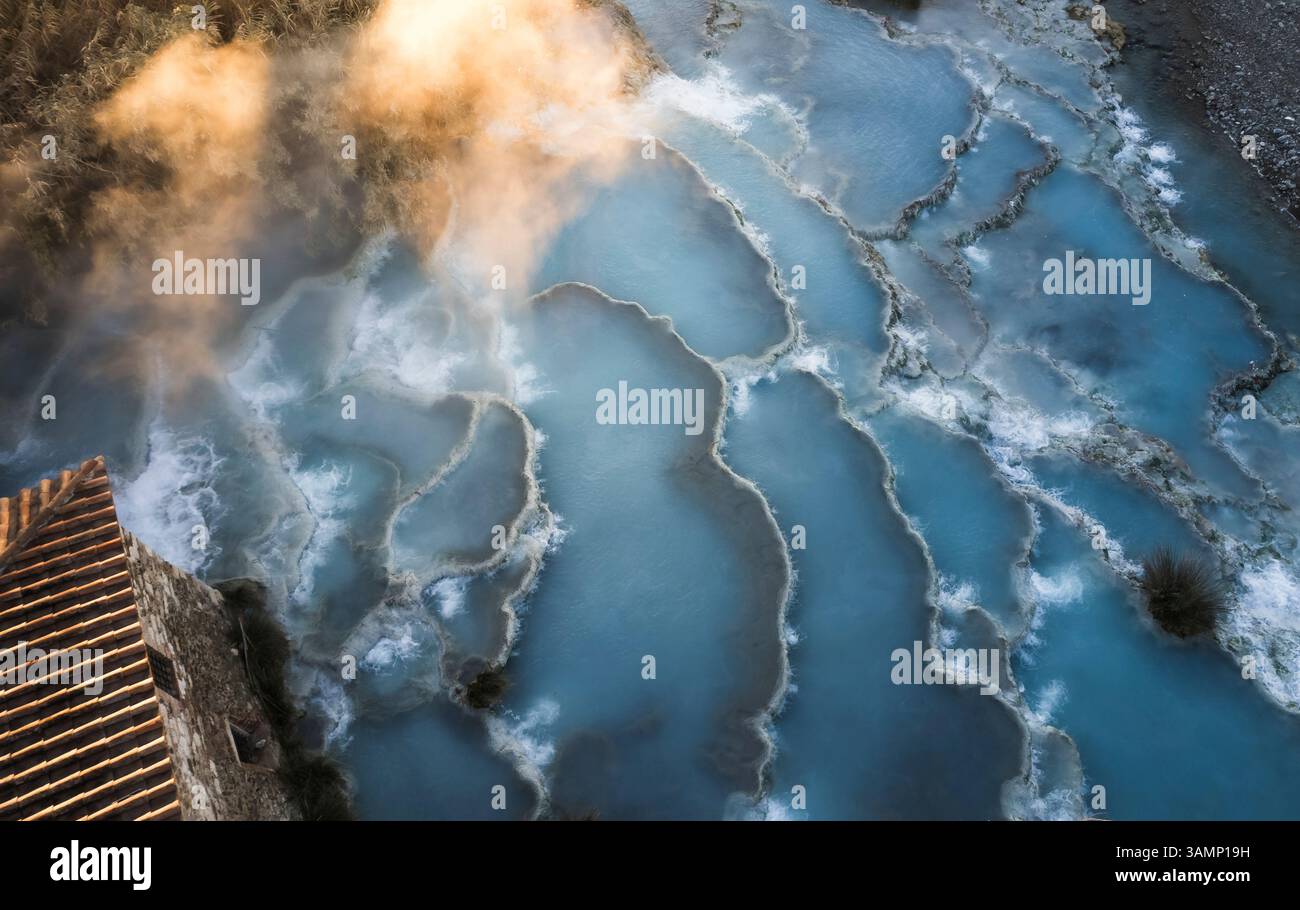 Aerial view of geothermal spa with blue water and steaming terraces ...