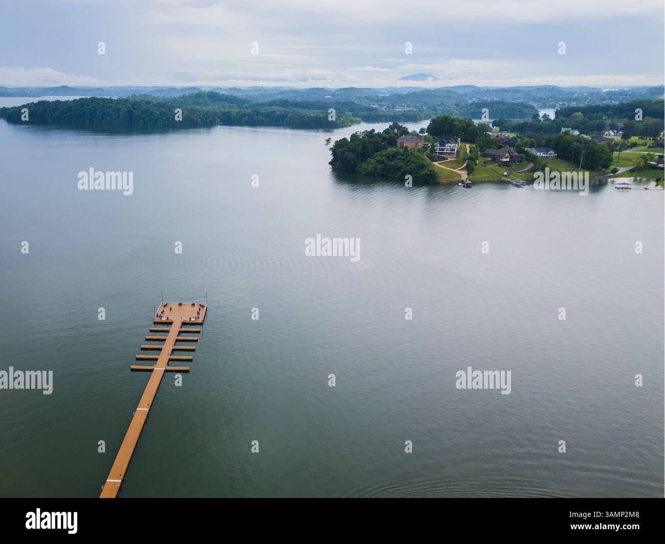 Aerial view of serene lake view with pier, residential area, and island ...