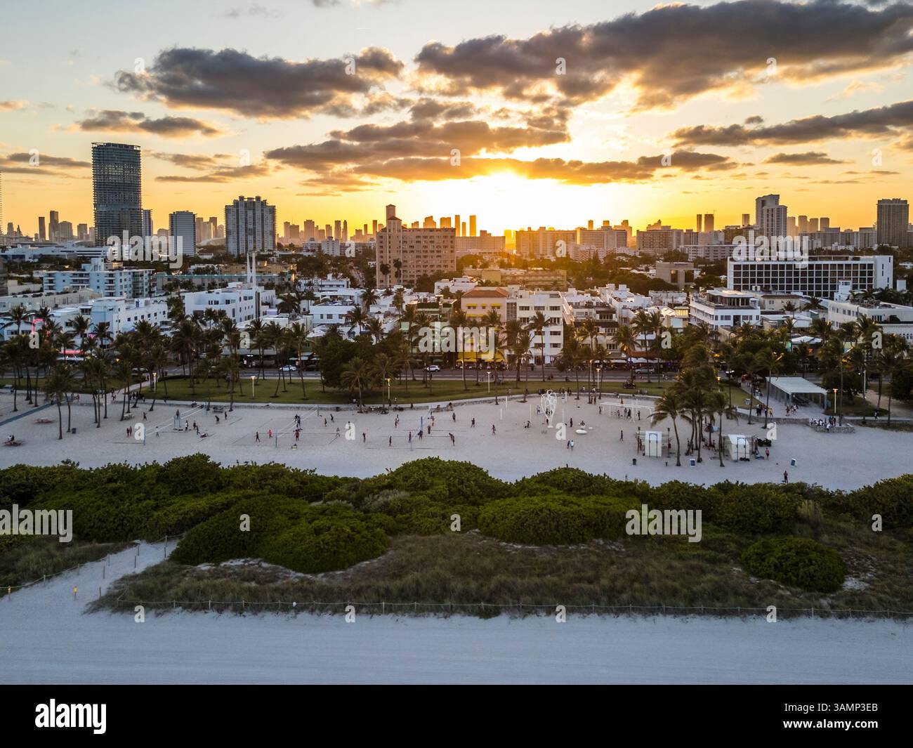 Aerial view of sunset over Miami Beach with volleyball players and palm ...