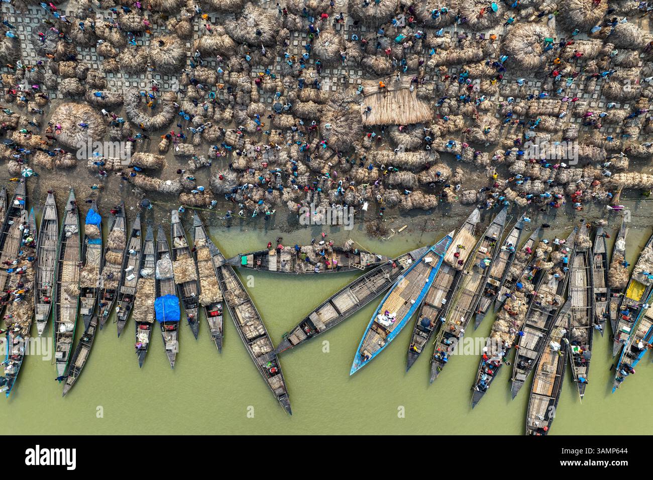 Aerial view of a busy raw jute market with traditional boats along the ...