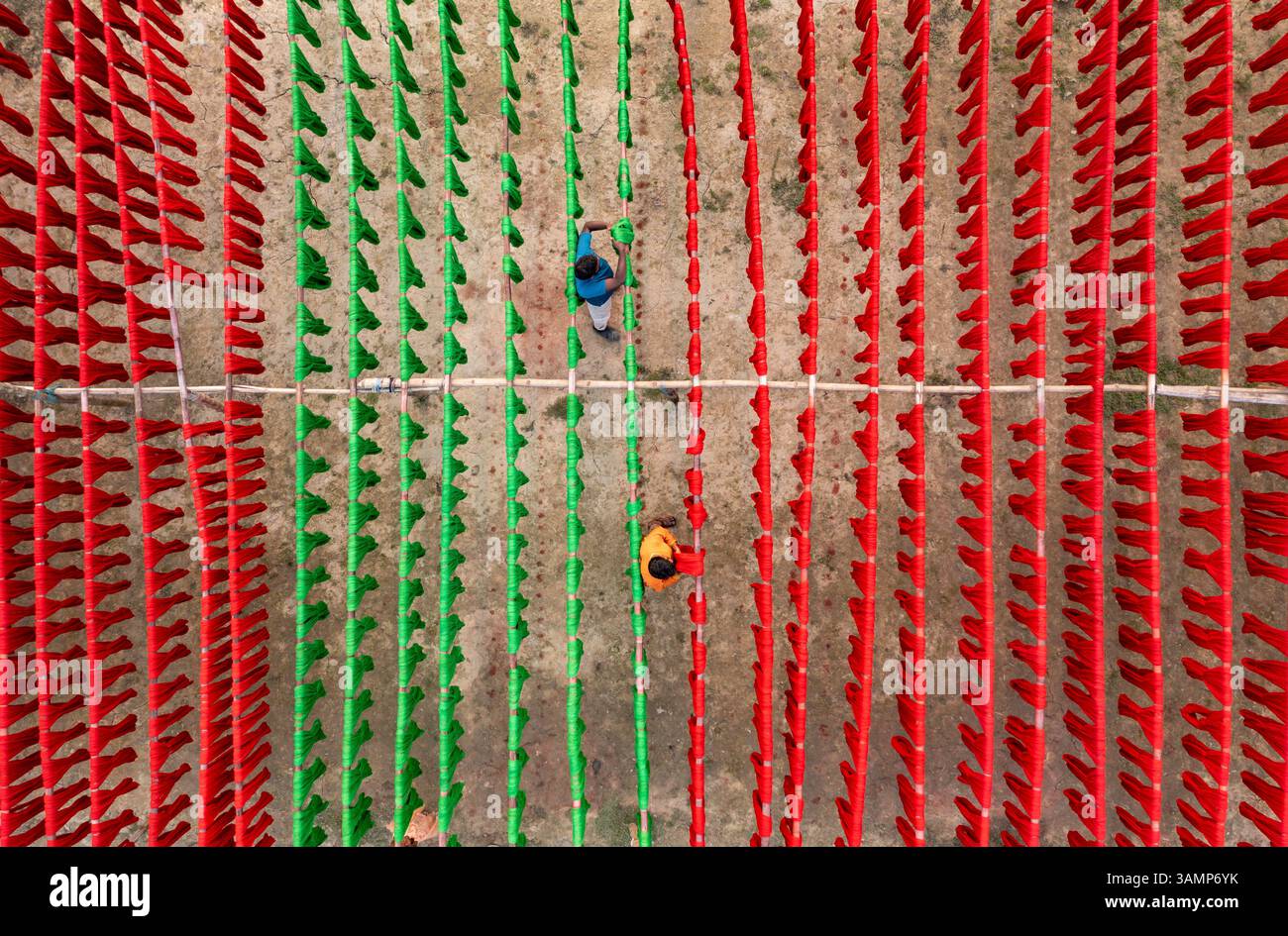 Aerial view of vibrant fabric dyeing process with colorful cloth rows ...