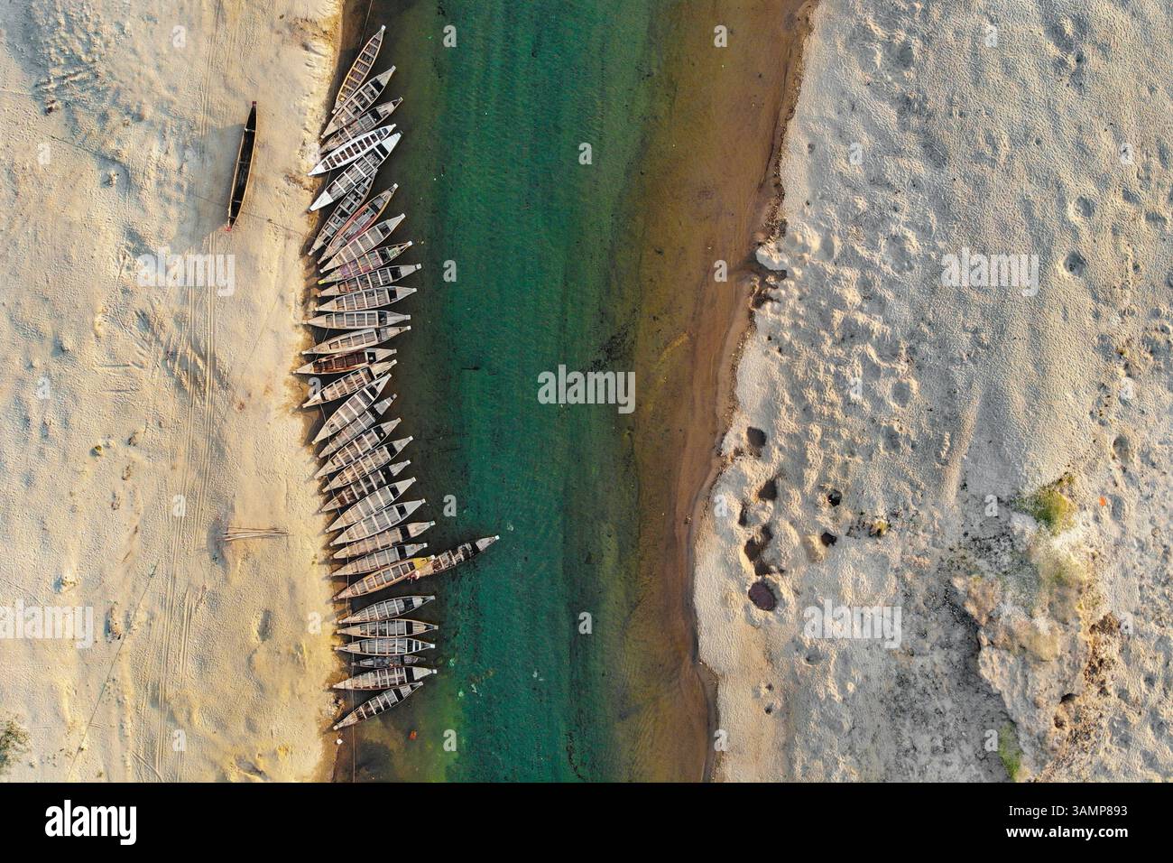 Aerial view of serene riverside boats along a tranquil river with sandy shores, Purba Jaflong ...