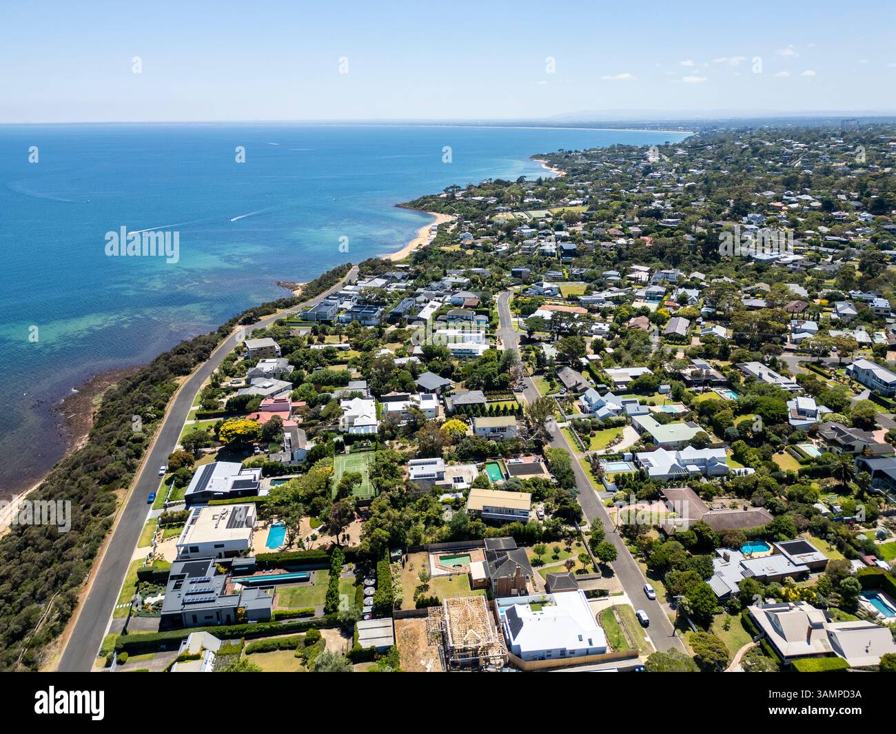 Aerial view of beautiful coastal homes along the serene ocean and beach ...