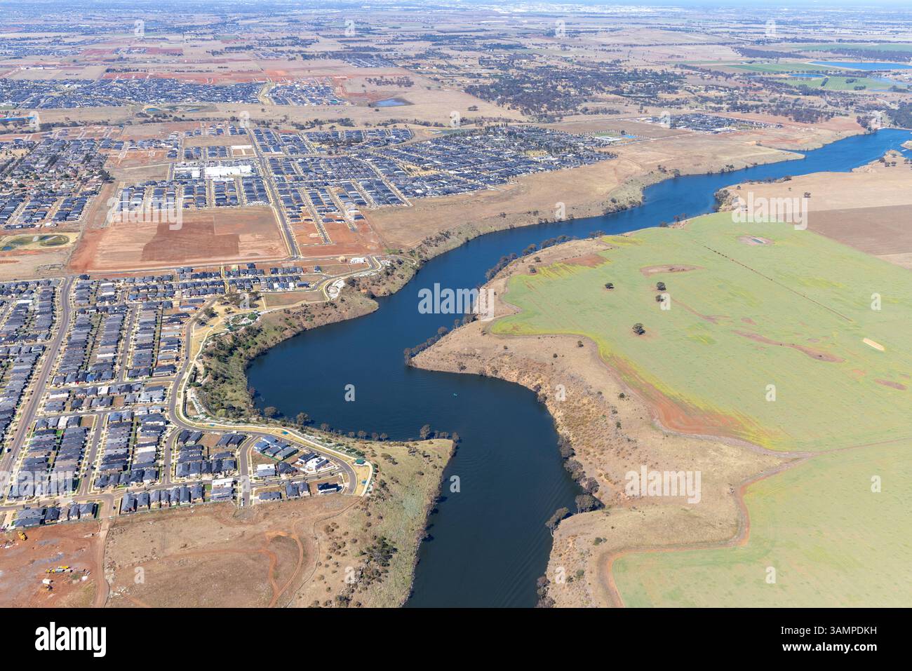 Aerial view of beautiful residential area and fields with a river, Weir ...