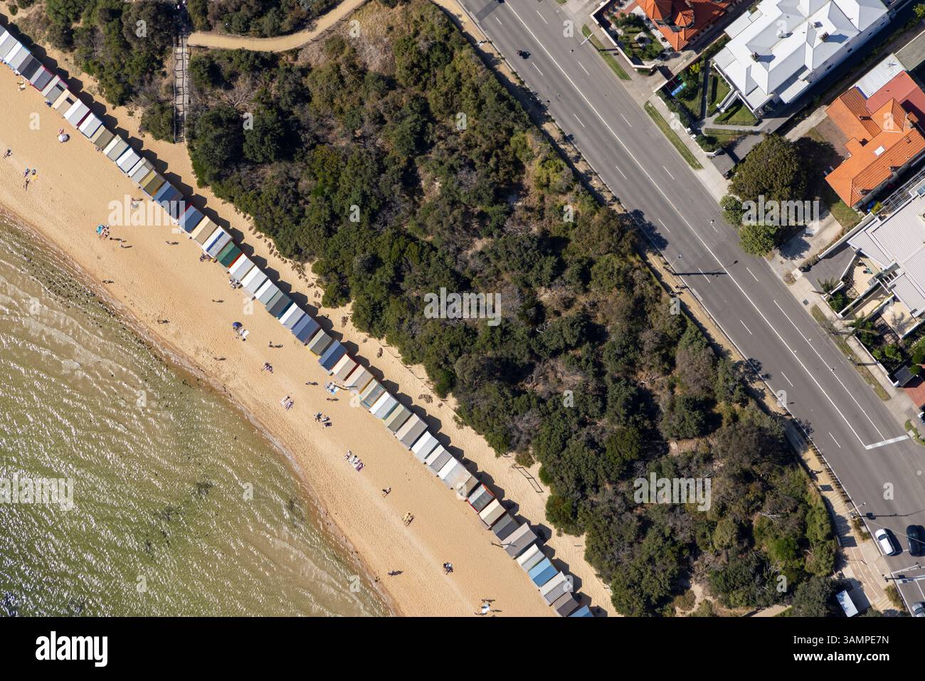 Aerial view of colorful beach huts along sandy Brighton beach with ...