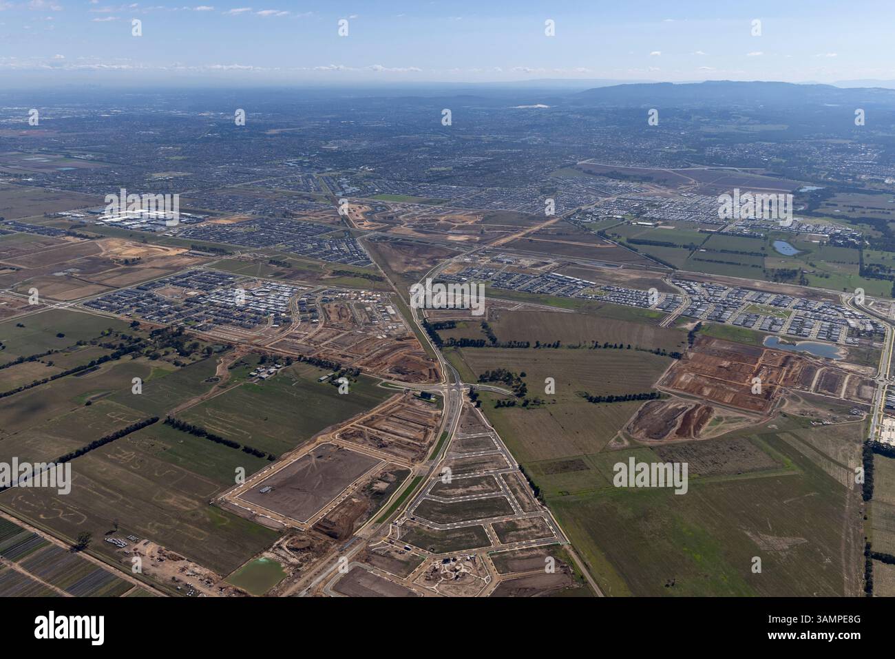 Aerial view of urban development with modern housing and green fields ...