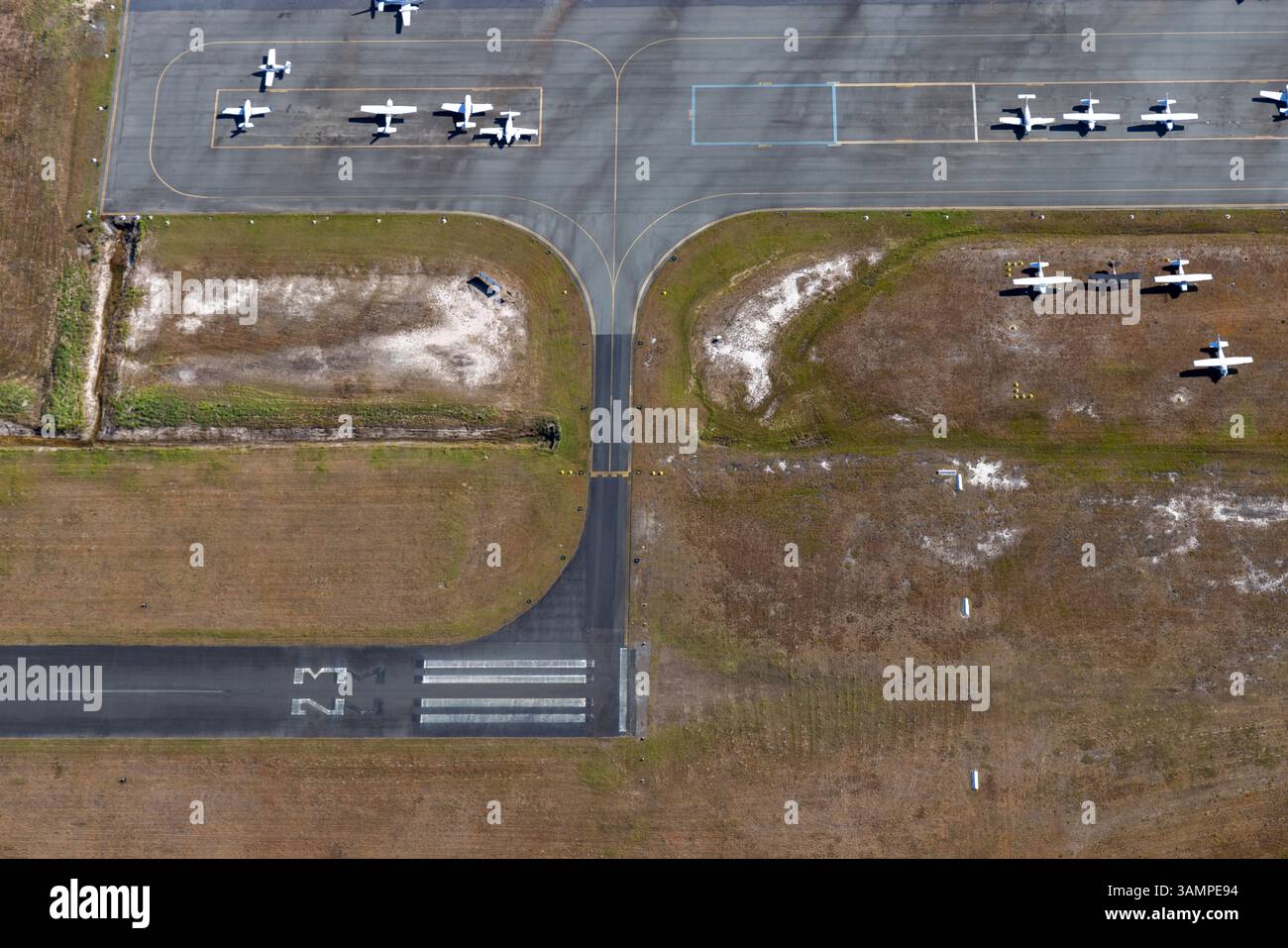 Aerial view of airport with small aircraft on runway and tarmac ...