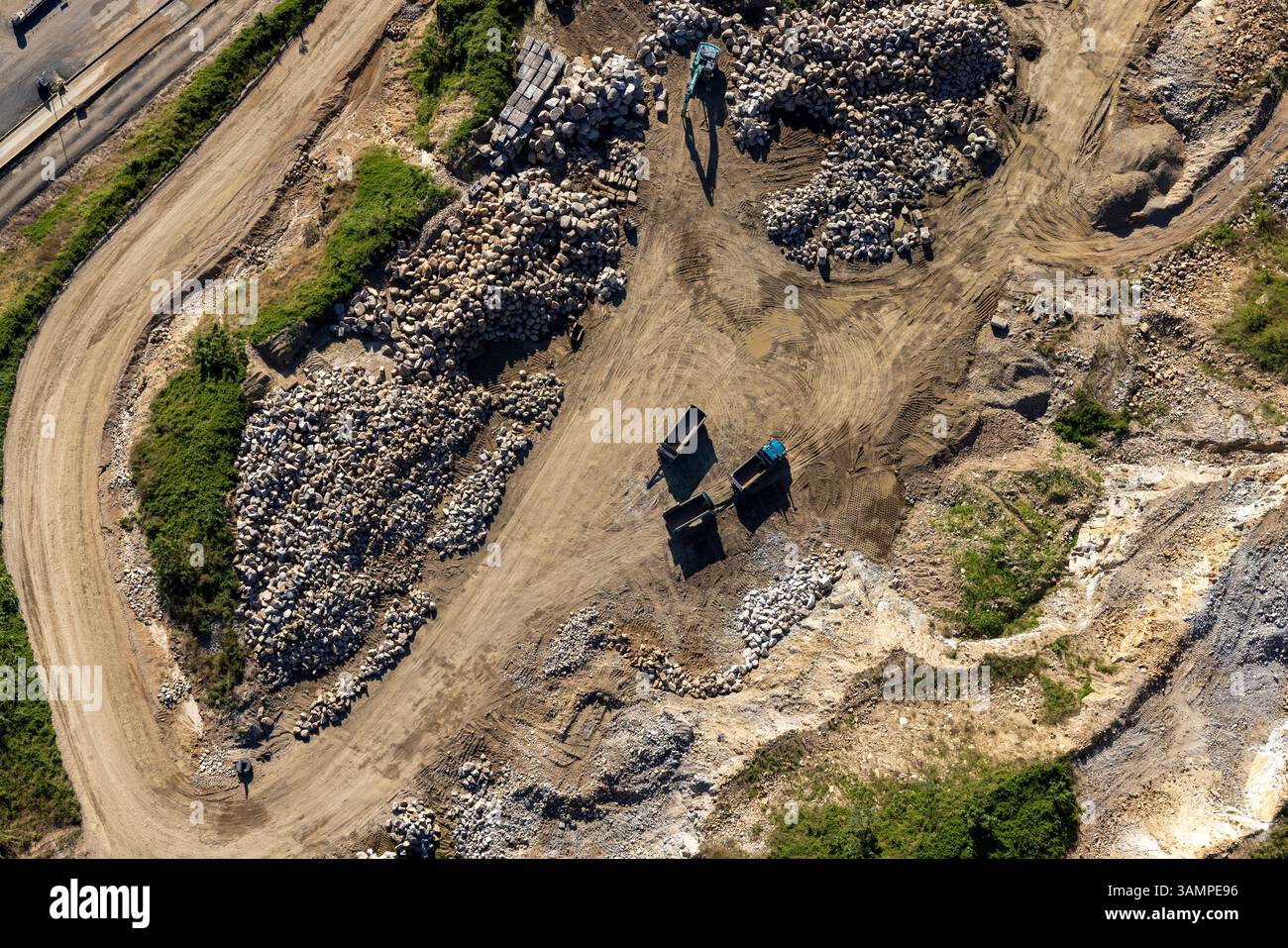 Aerial view of a construction site with heavy machinery and rock piles ...