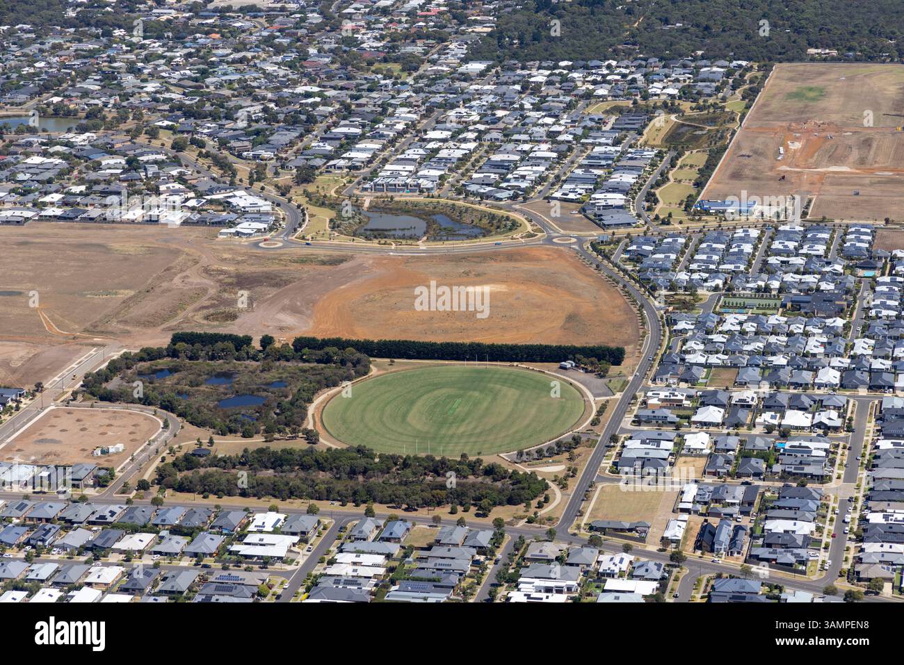 Aerial view of suburban neighborhood with homes, roads, and green park ...