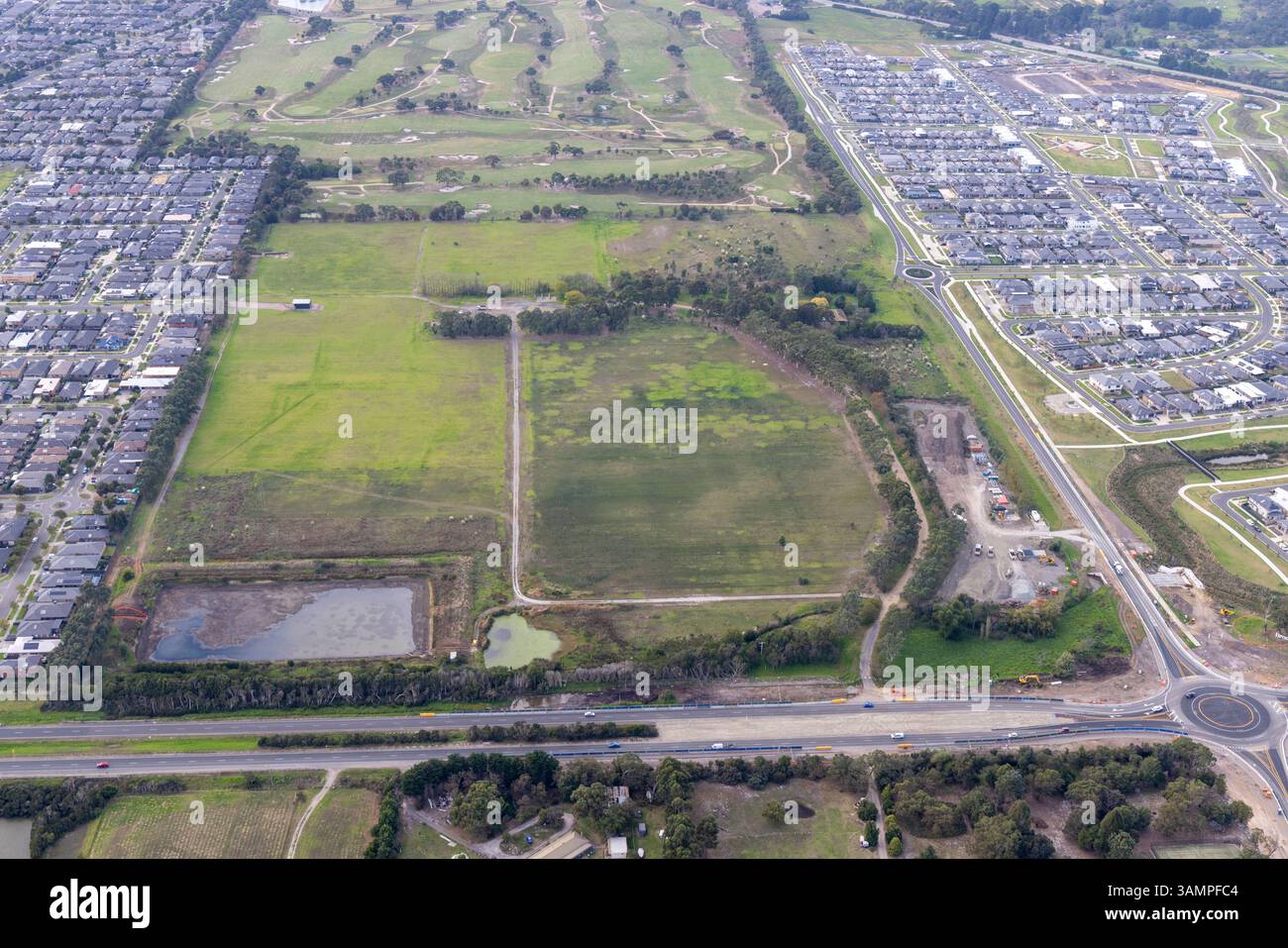 Aerial view of suburban housing and roads with green fields in a modern ...