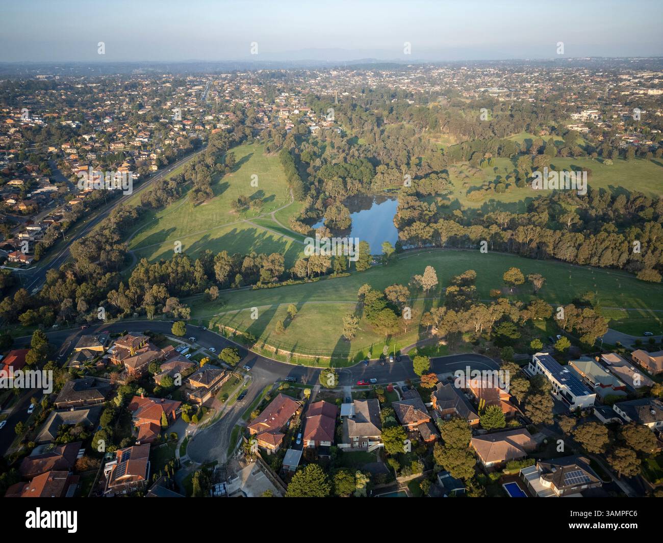 Aerial view of serene suburban landscape with greenery, park, and lake ...