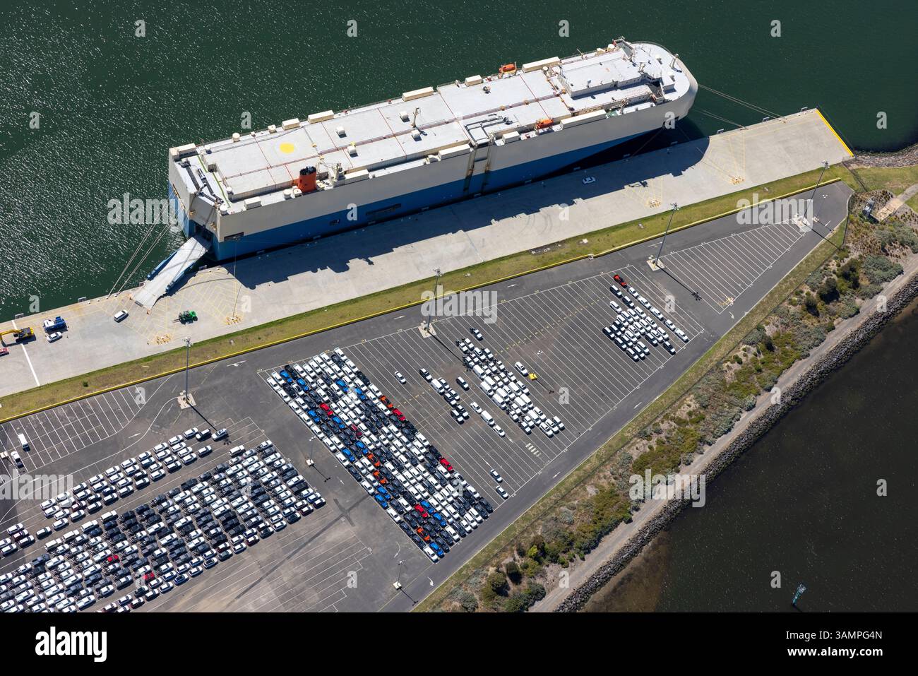 Aerial view of industrial port with cargo ships and parking lot filled ...