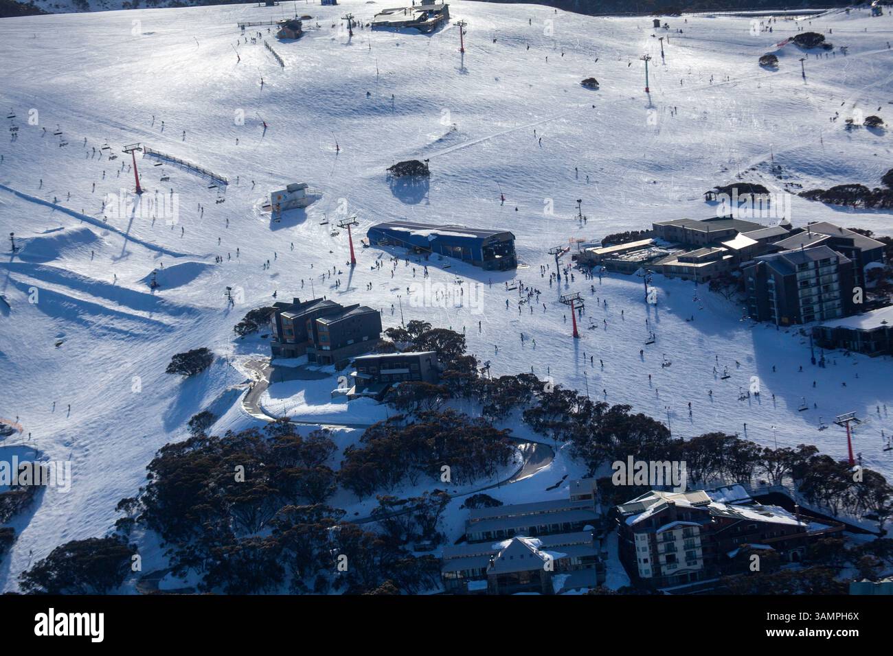 Aerial view of snowy Mount Buller ski resort with buildings and trees ...
