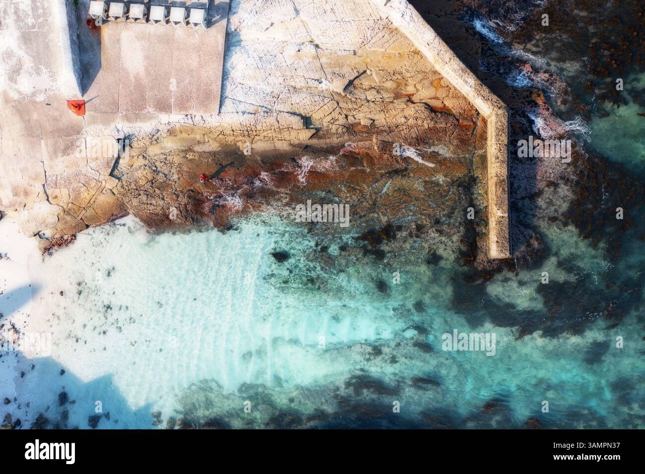 Aerial view of an old fishing harbour with clear blue water and a ...
