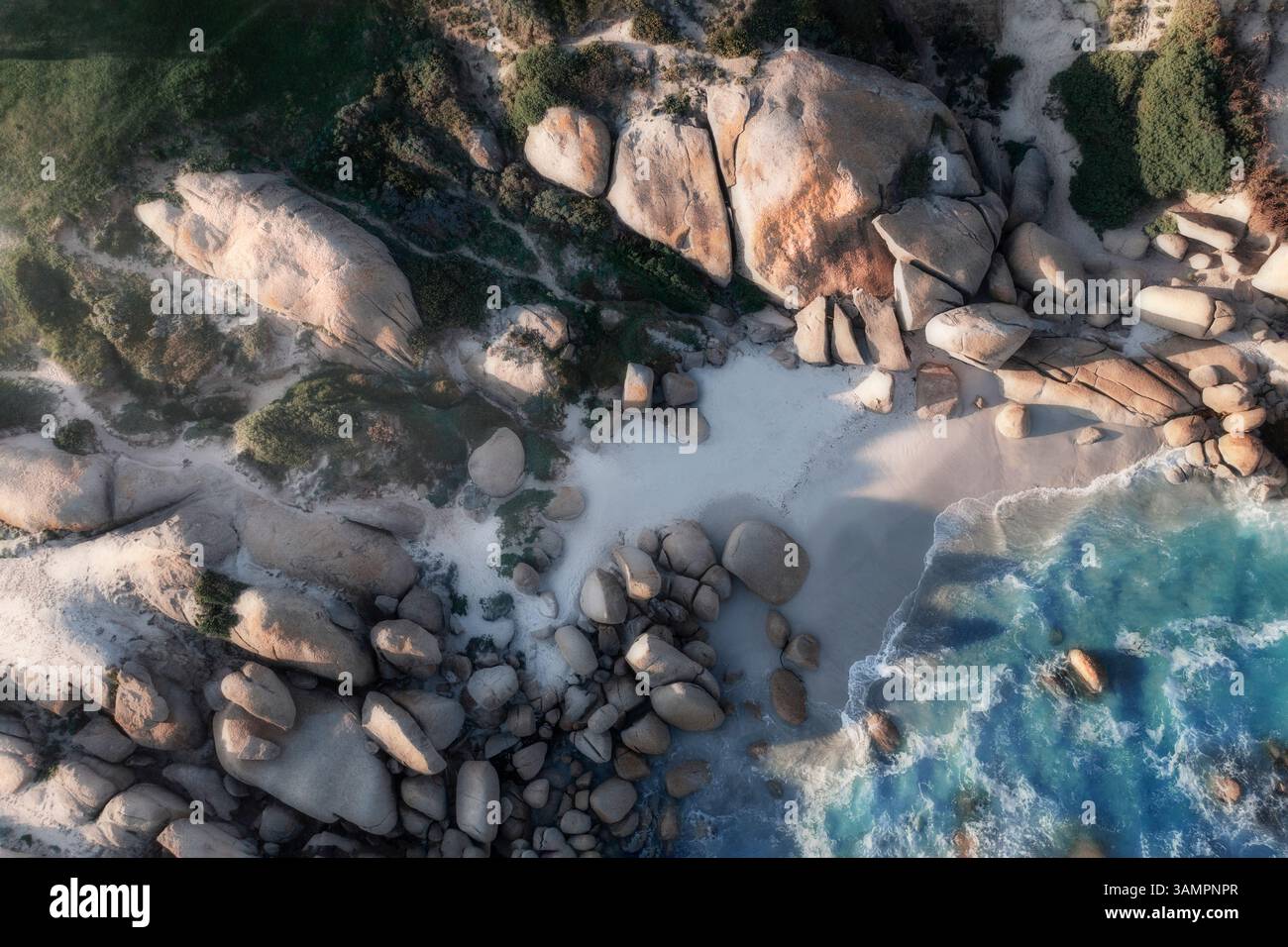 Aerial view of a cove, secluded beach surrounded by towering boulders ...