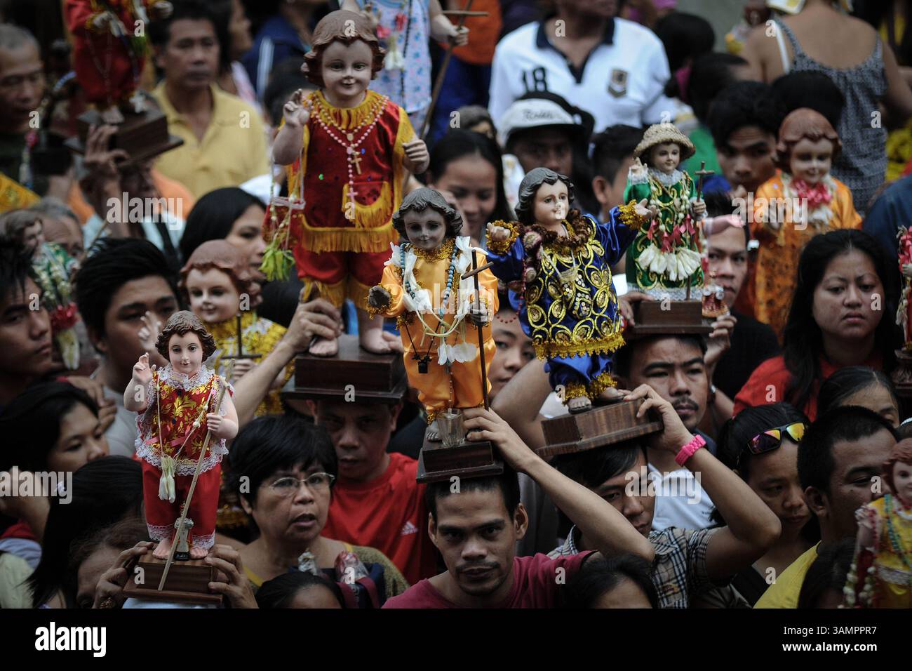 Jan. 19, 2014 - Manila, Philippines - Filipino Catholics raise their Santo Nino statues before ...
