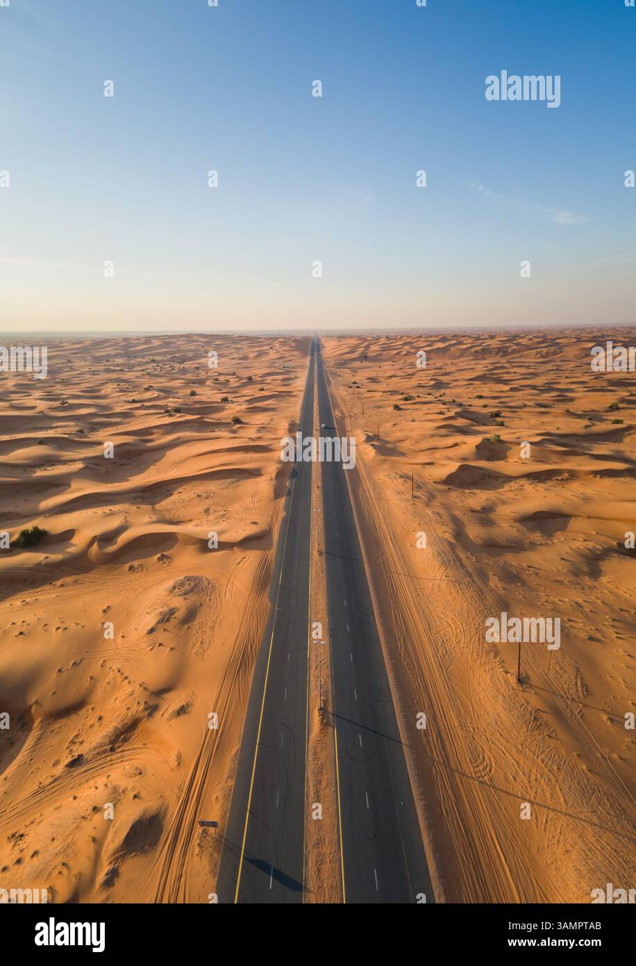 Aerial view of a straight long road in the middle of Sharjah desert in ...