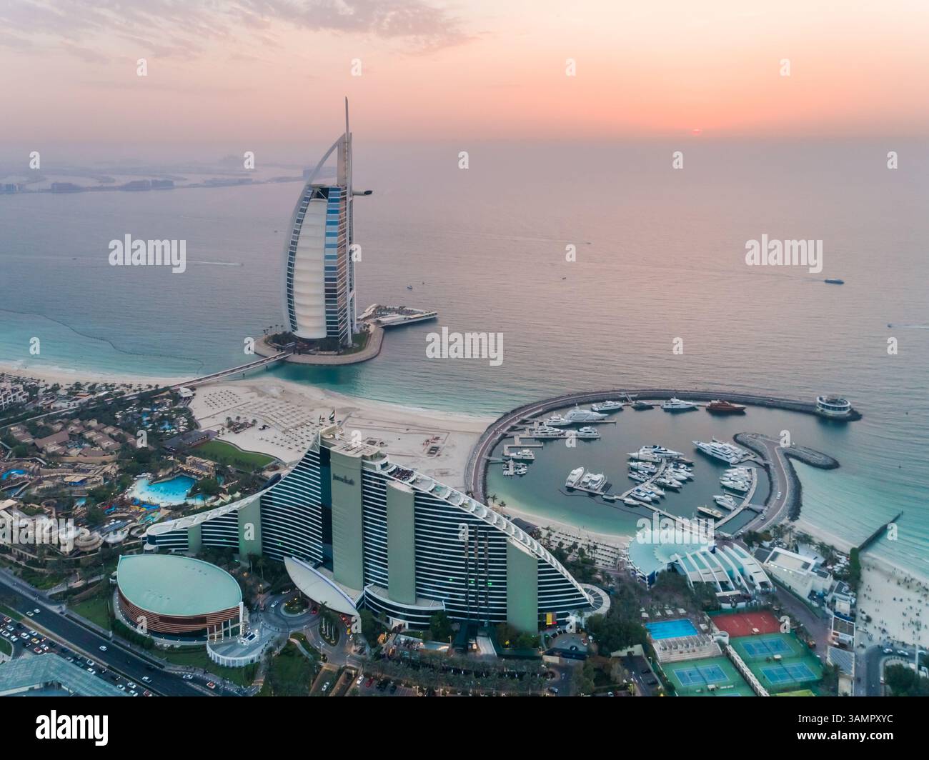 Aerial view of the luxurious Burj Al Arab Hotel and harbour at sunset ...