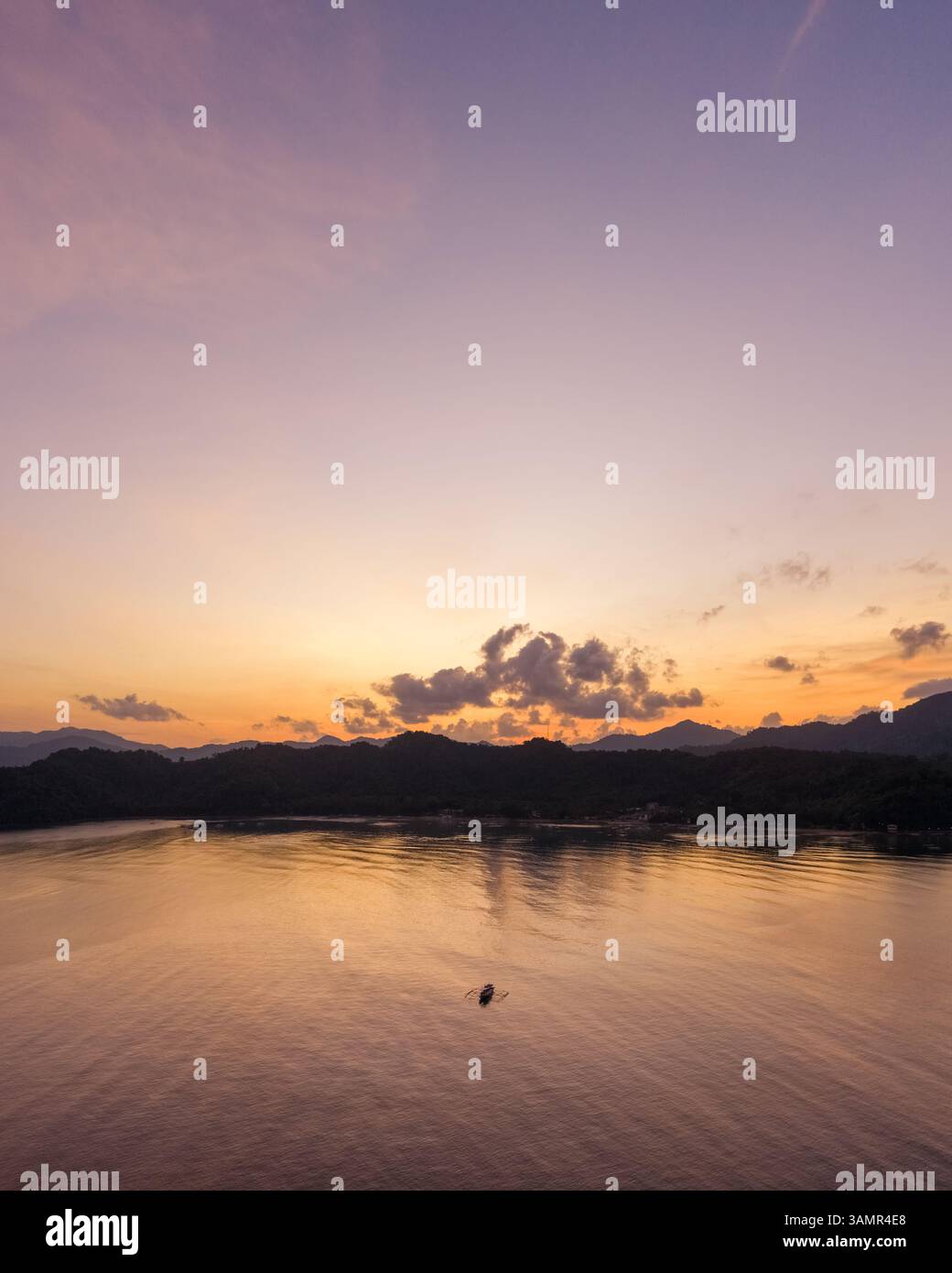 Aerial view outrigger sailing at sunset in the bay of El Nido, the ...