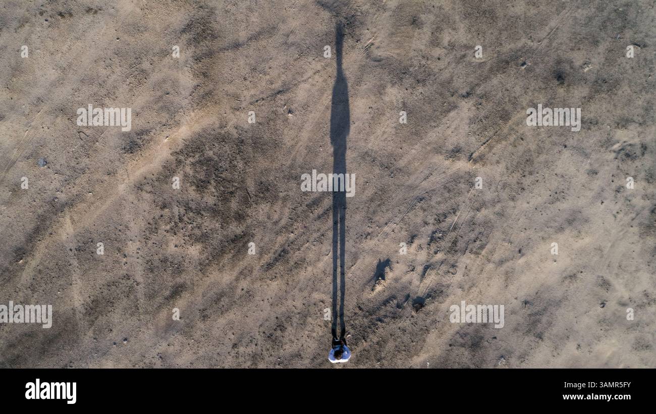Aerial selfie of a man playing with his shadow on the beach in Dubai ...