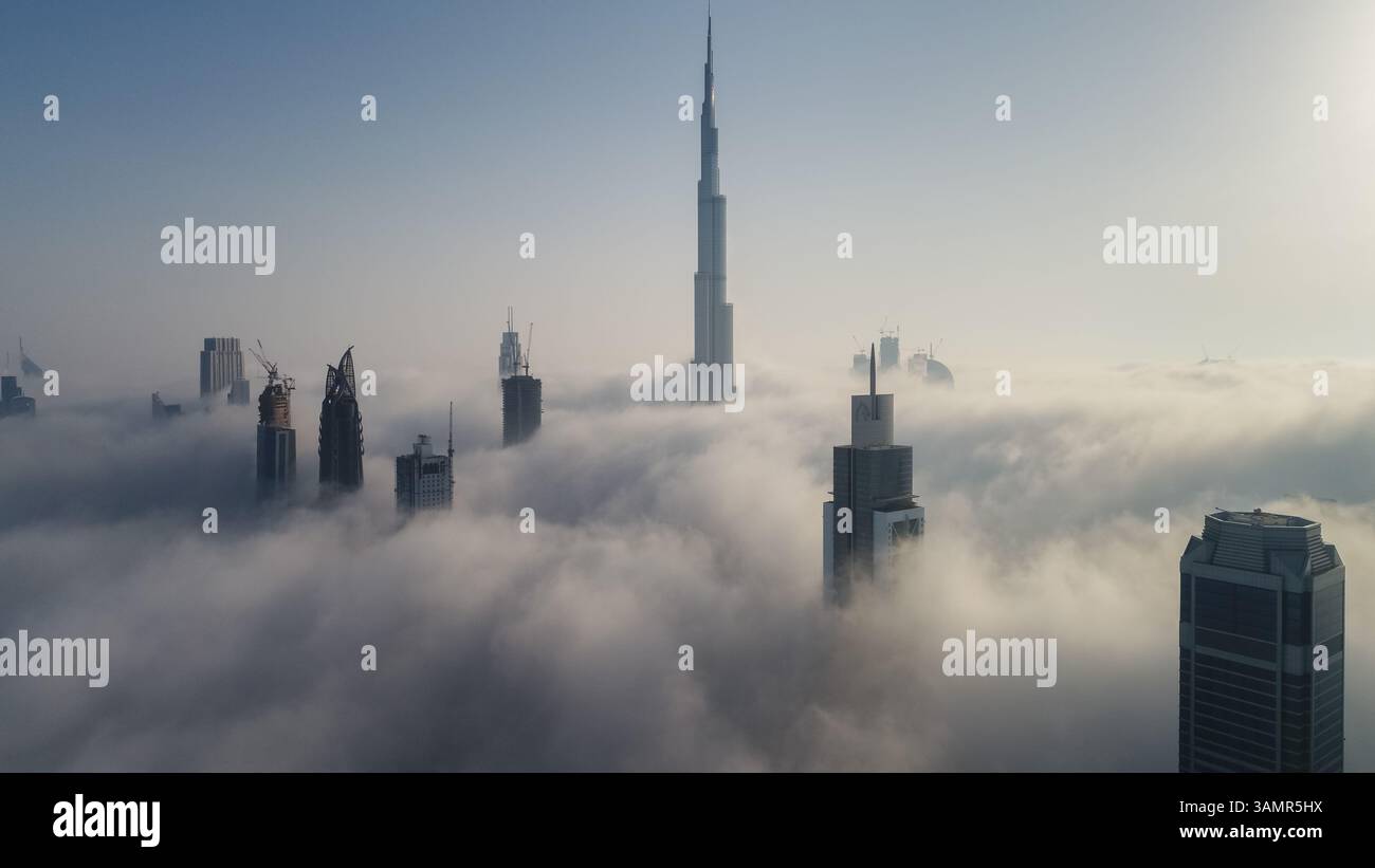 Aerial view of skyscrapers and Burj Khalifa tower in the clouds of ...