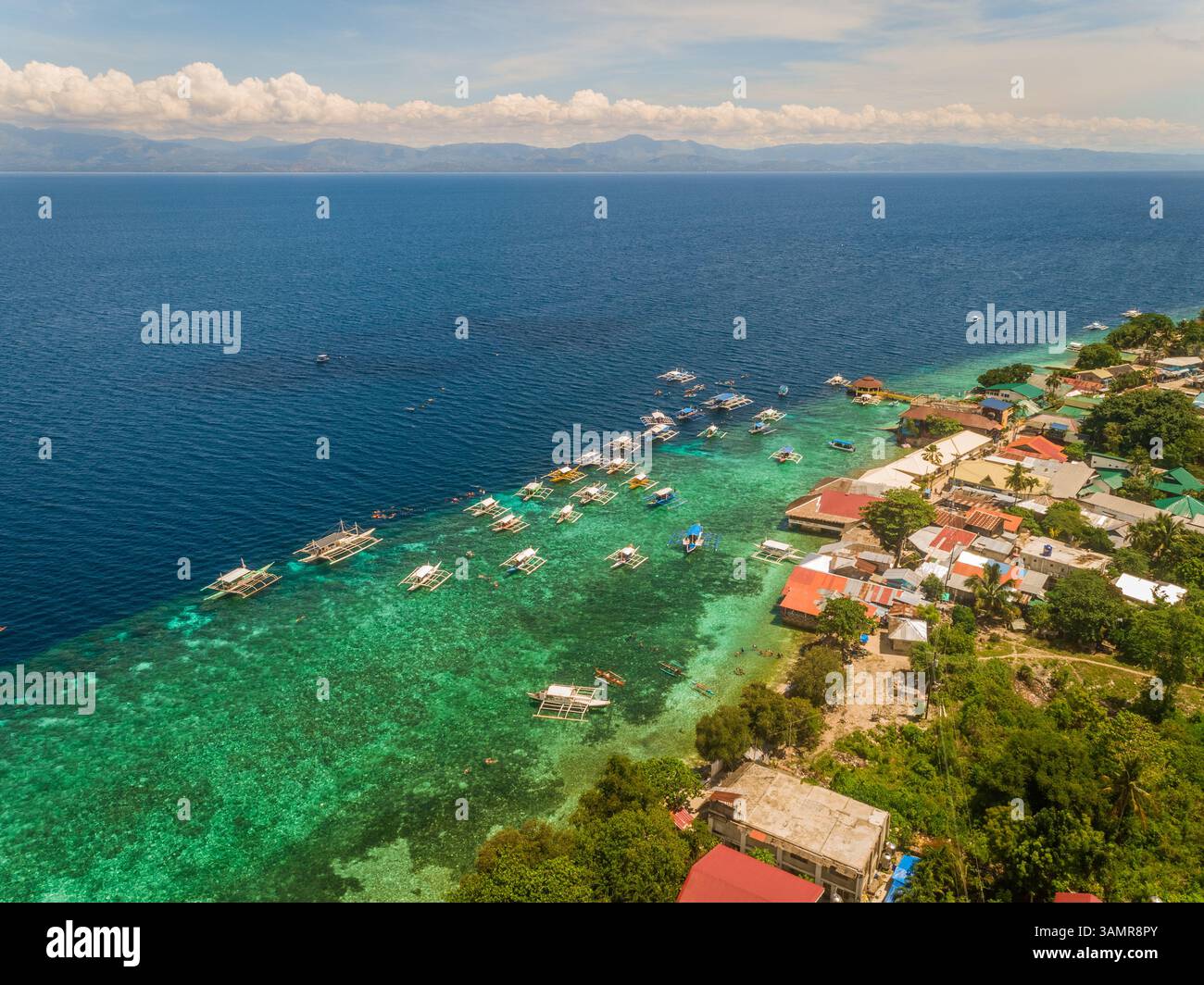 Aerial view of resort, coral reef and filipino boats, Moalboal ...