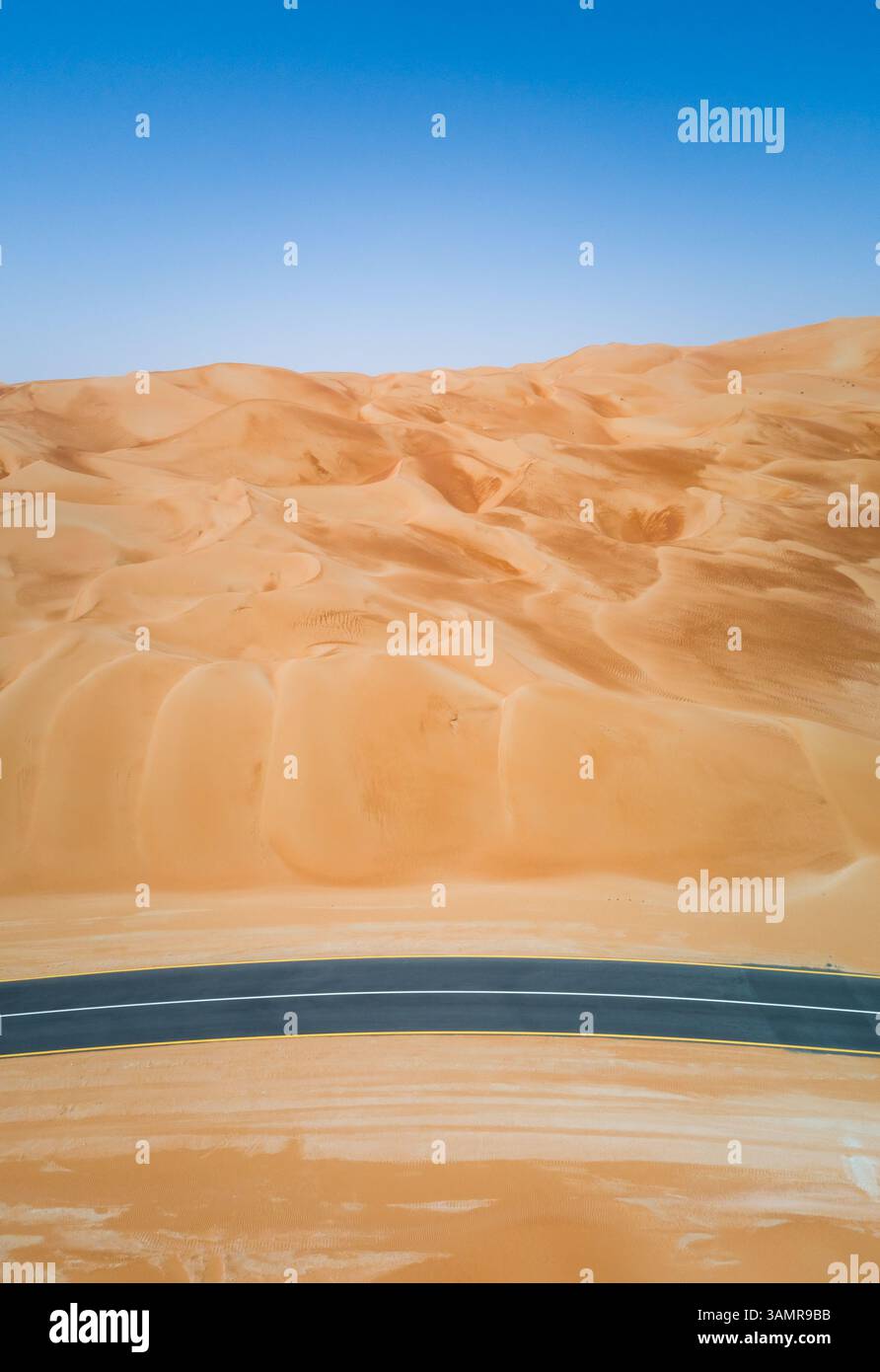 Aerial view of an empty curved road in the desert of Abu Dhabi, U.A.E ...