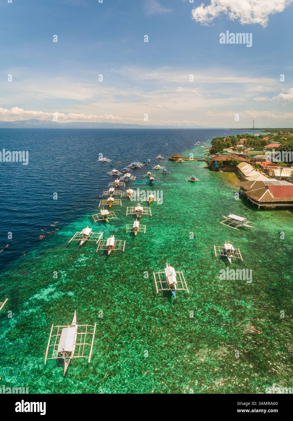 Aerial view of resort, coral reef and filipino boats, Moalboal ...