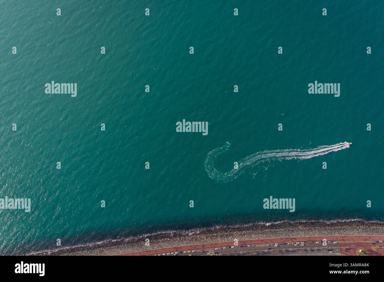 Aerial abstract view of speed boat and water trail by long road in ...