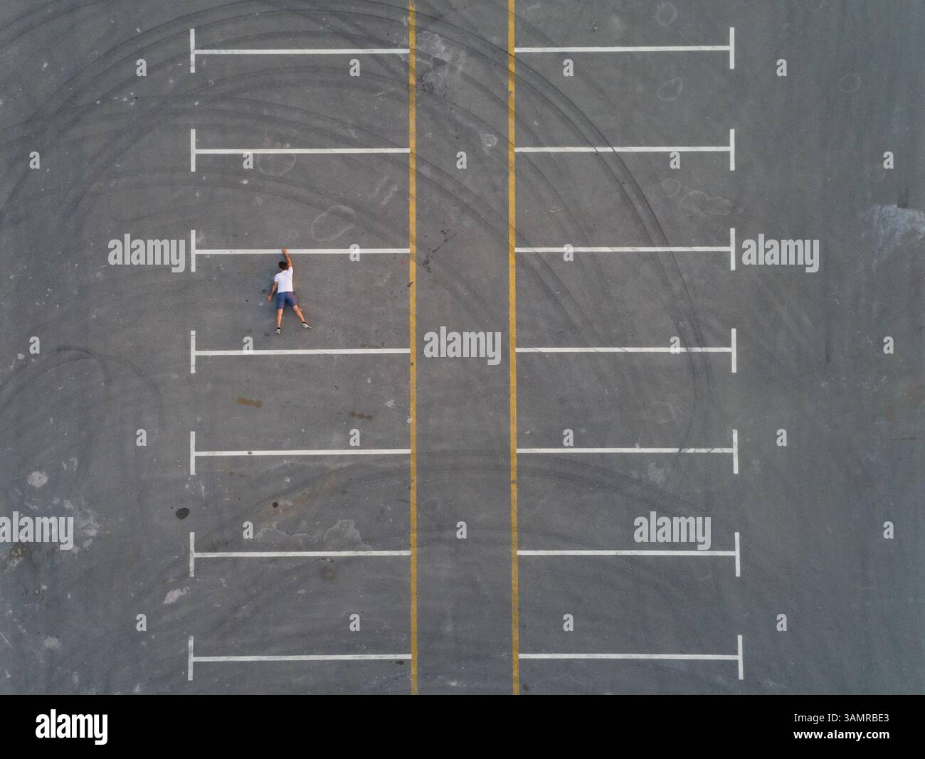 Aerial conceptual view of a man falling from a parking line in Dubai, U ...