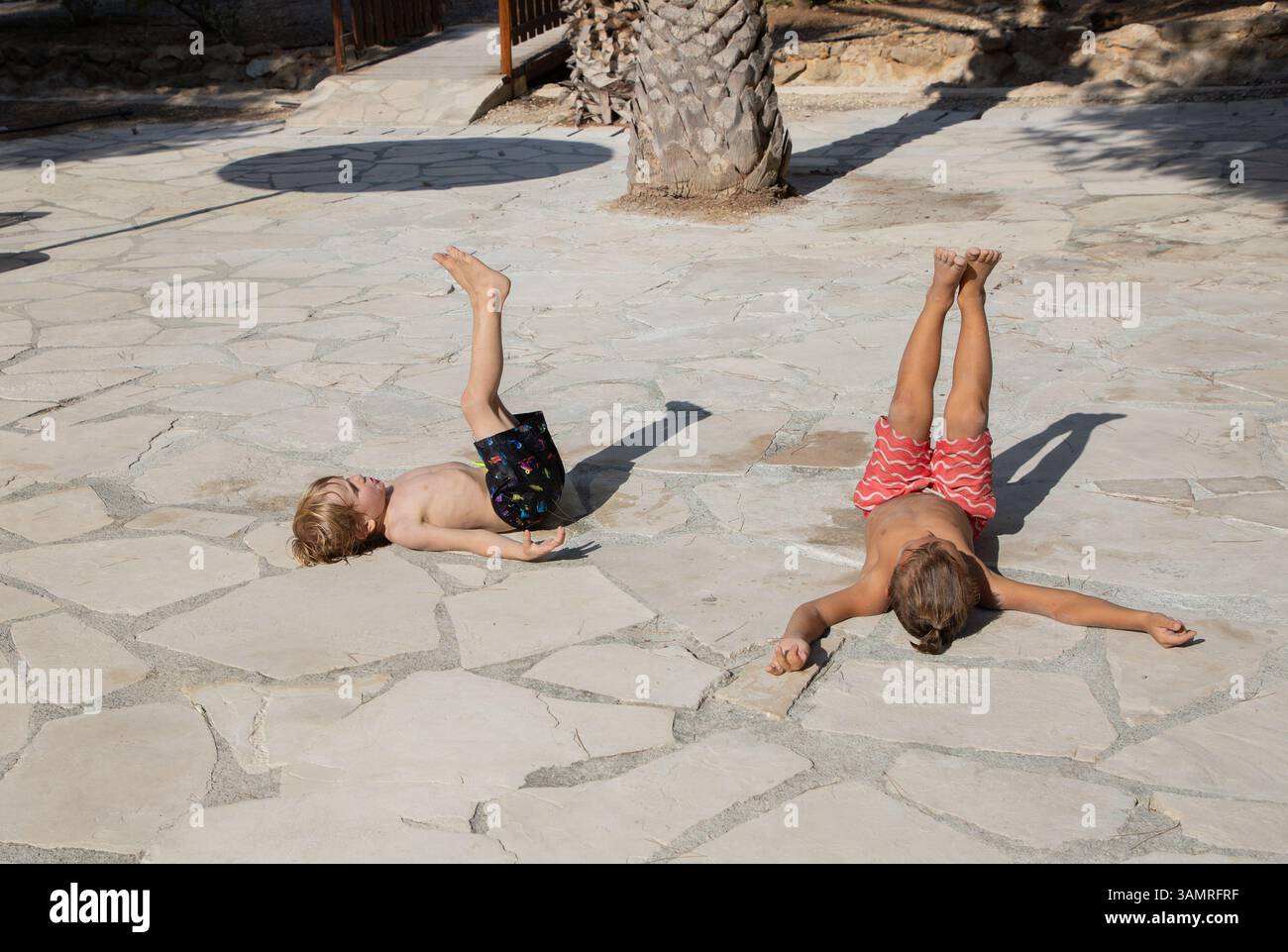 Two barefoot children, boys 5-6 years old, sunbathing and having fun ...