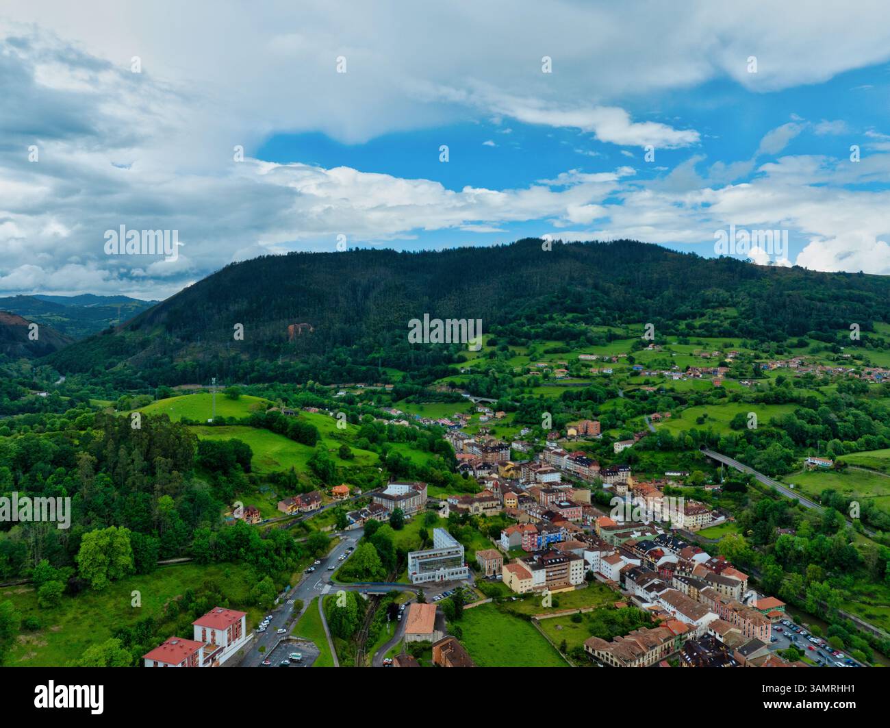 Aerial view of vibrant village nestled among hills and mountains ...