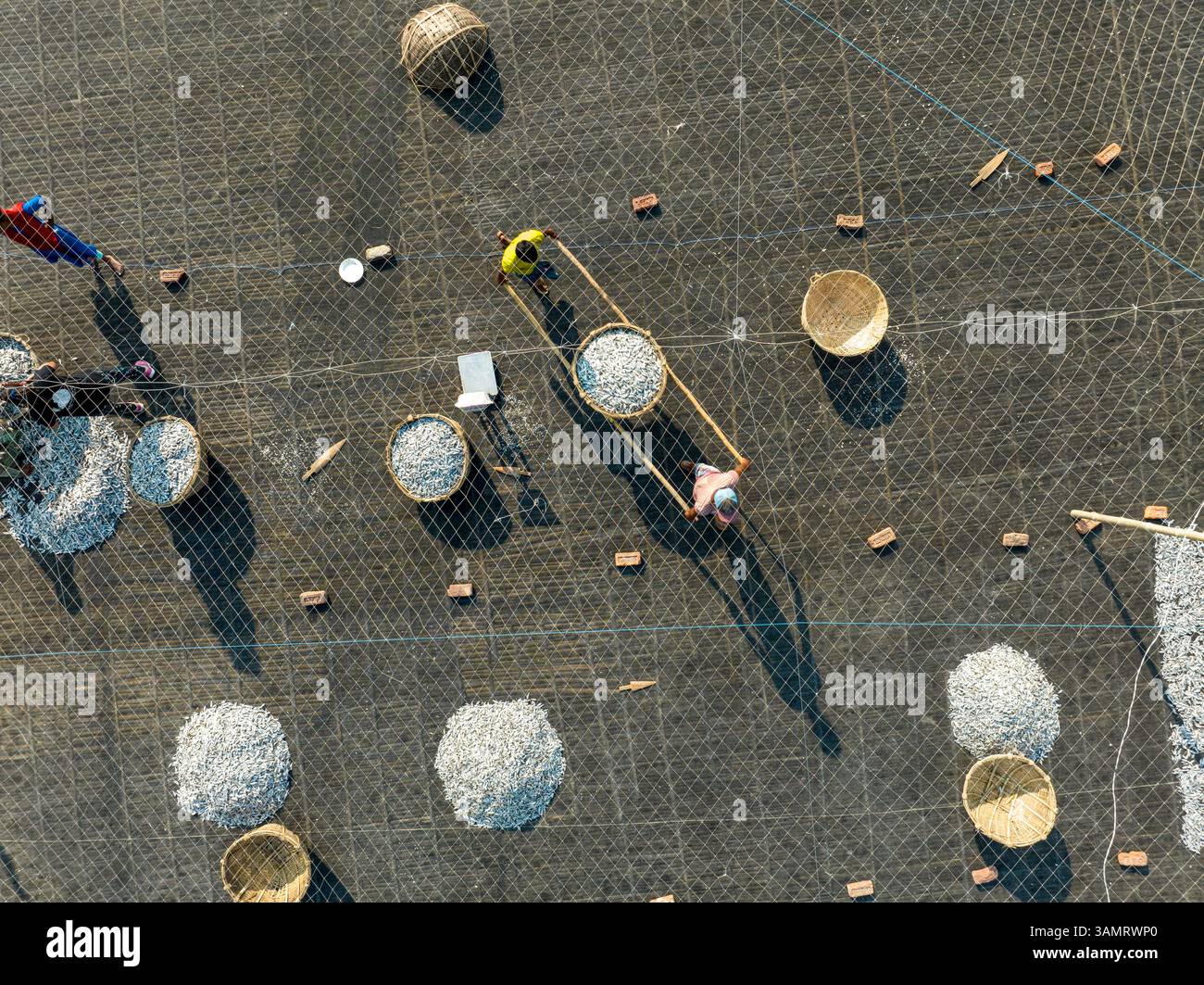 Aerial view of people working in a fish market drying fish at Lalpur ...