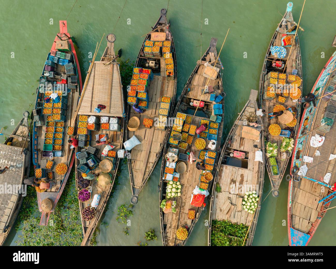 Aerial view of people trading with fruits and vegetables on boats along ...