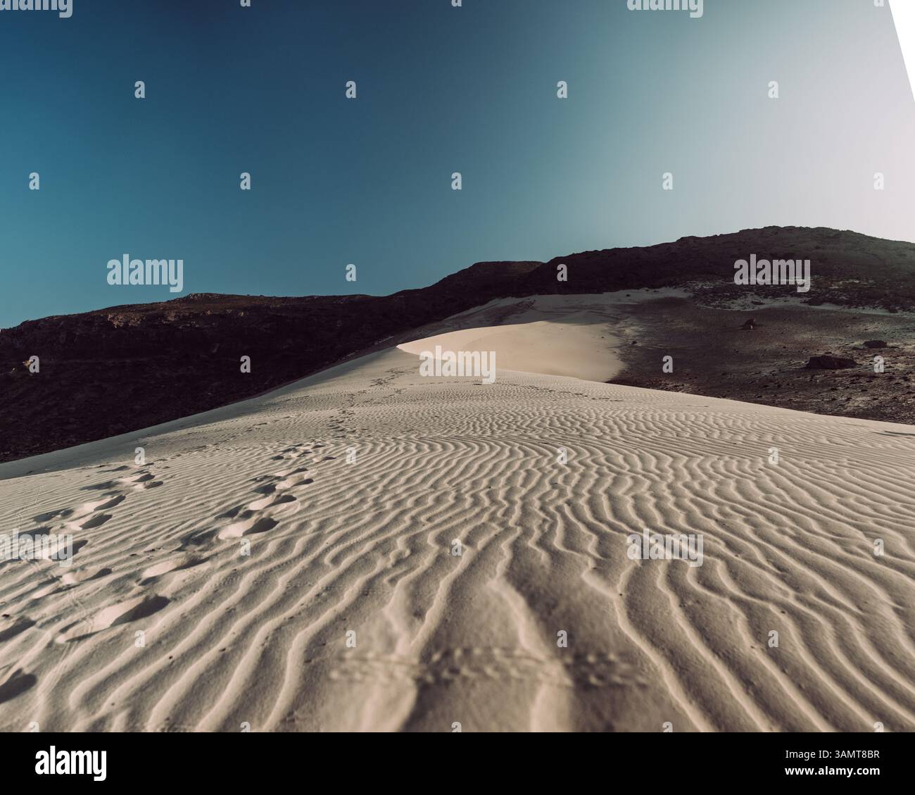 Footprints trail across wind-sculpted sand dunes on Delisha Beach ...